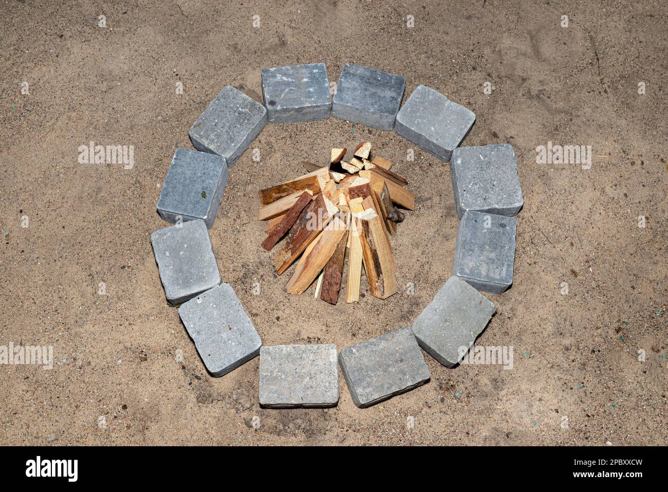 Prepared chopped pieces of wood to make a fire in a stone circle on the ...