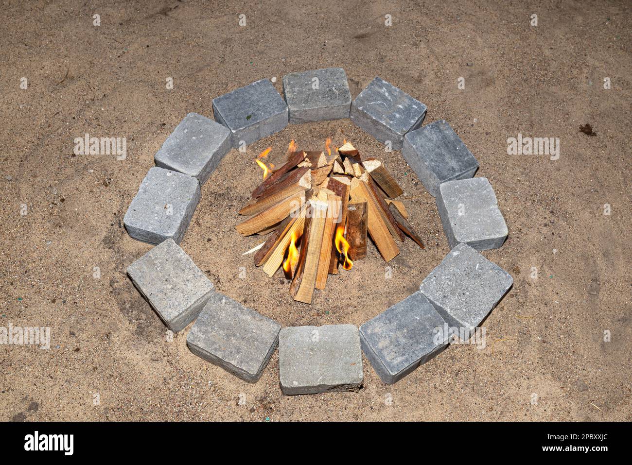 Prepared chopped pieces of wood to make a fire in a stone circle on the ...