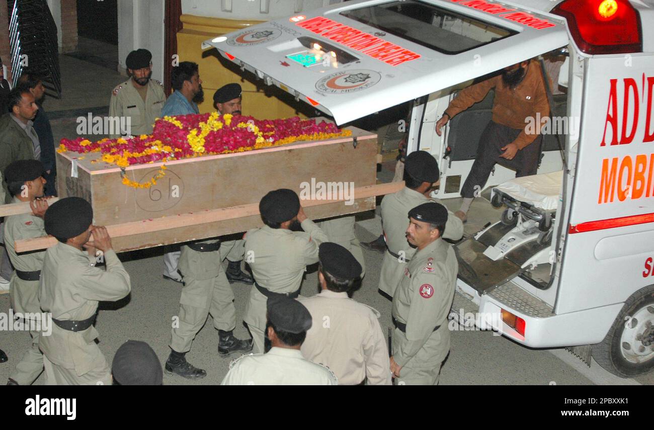 Pakistani paramilitary troops load the coffin of a victim of Sunday's ...