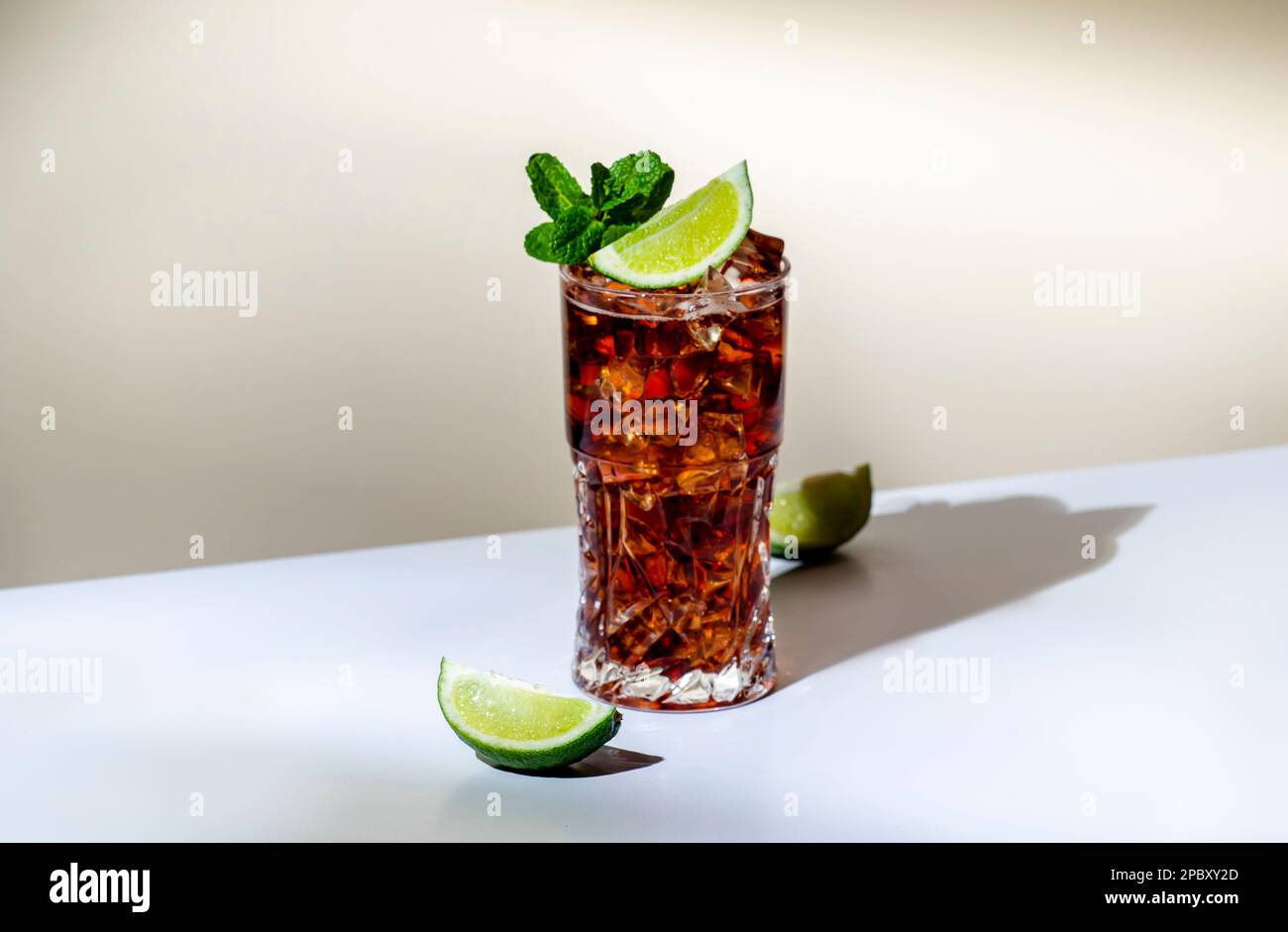 Rum cola cocktail with strong alcohol and ice, garnished with mint and ...
