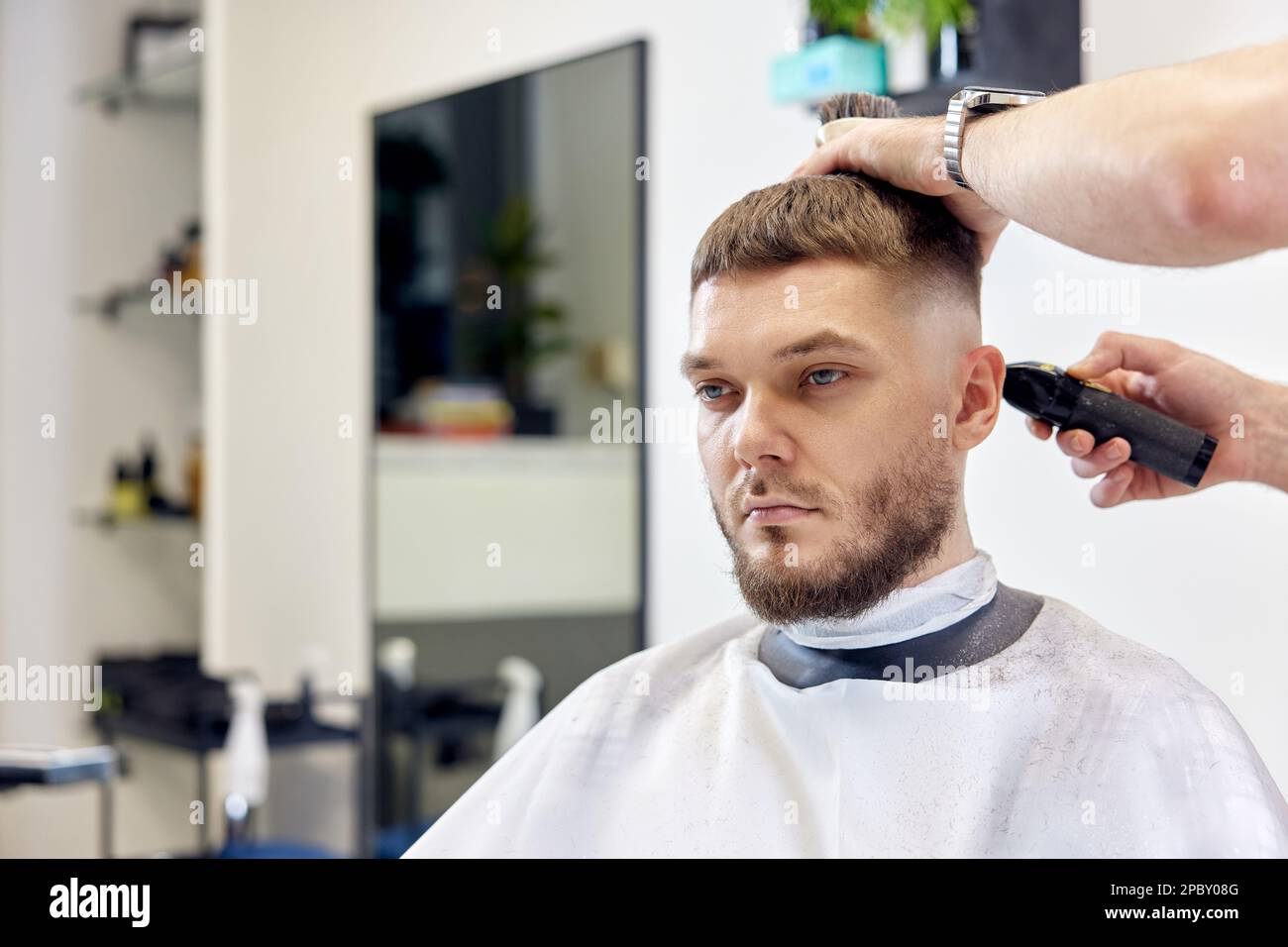 Barber trim hair with clipper on handsome bearded man Stock Photo - Alamy