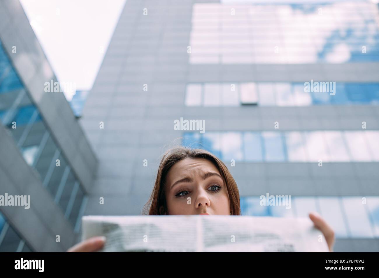 puzzled confused perplexed woman reading newspaper Stock Photo - Alamy