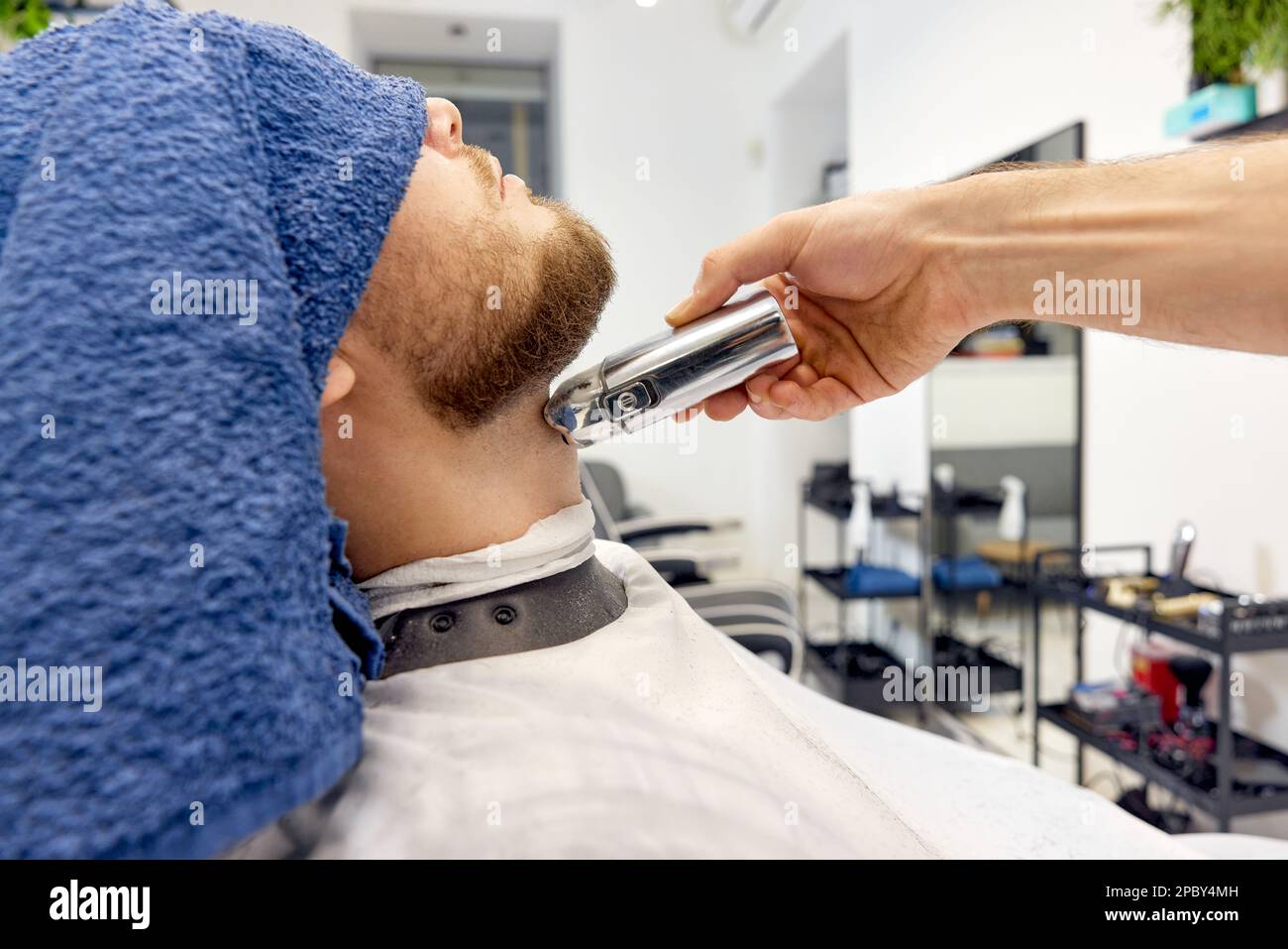 Barber shaving bearded man in barber shop Stock Photo - Alamy