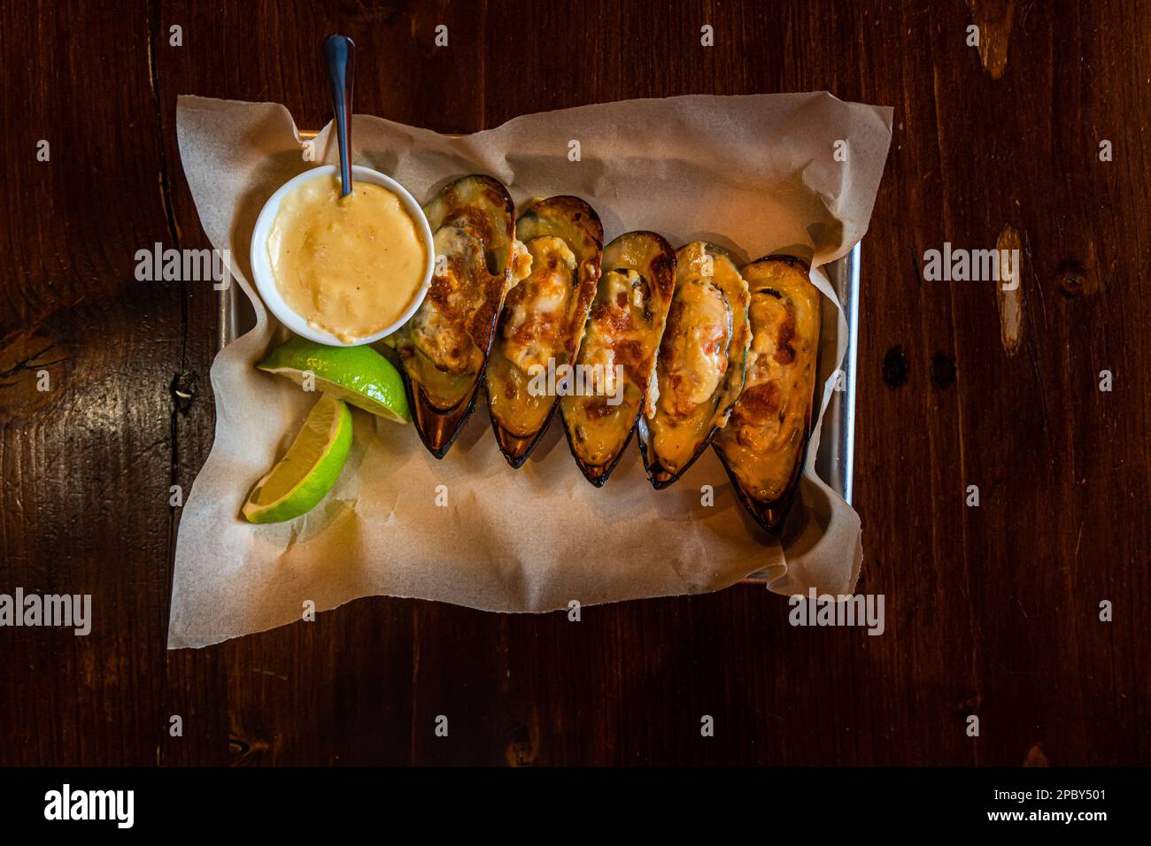 Baked shellfish mussels with cheese sauce served with lime slice Stock ...