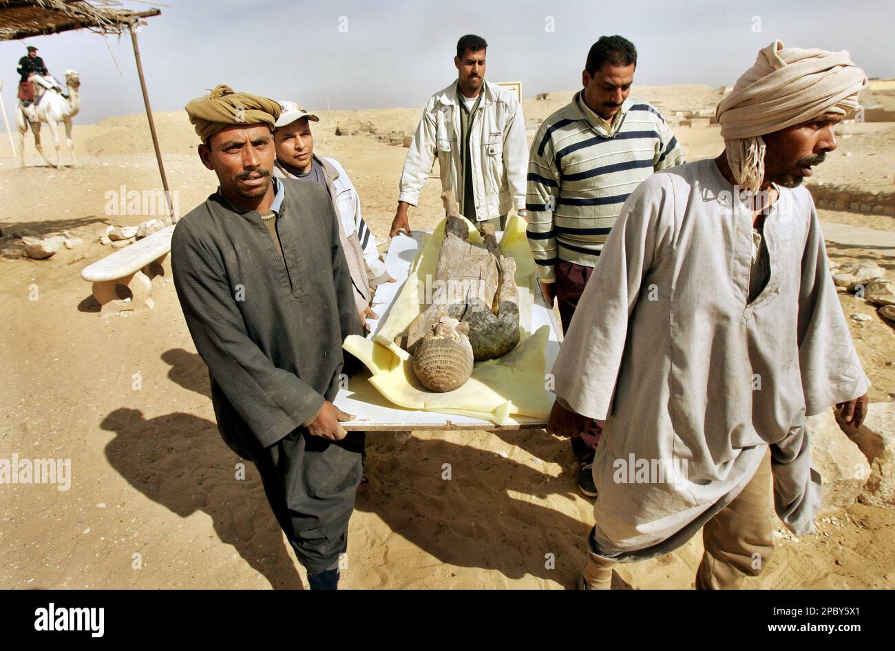 Archaeological workers remove a wooden statue from a more than 4,000 ...