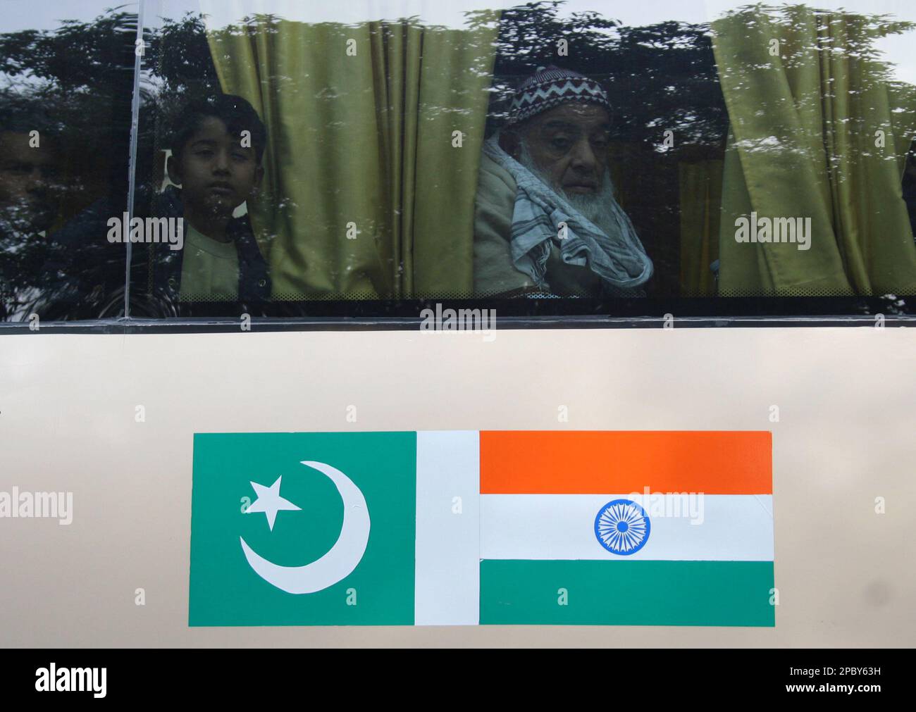 Passengers look out through the window of an India-Pakistan bus before ...