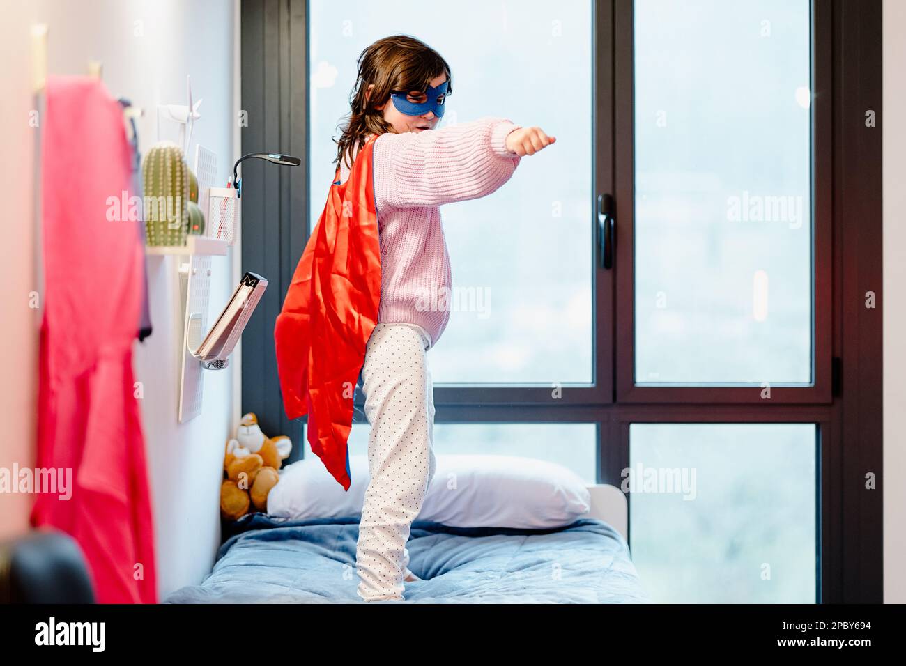 Full body side view of adorable little girl with dark hair in warm ...