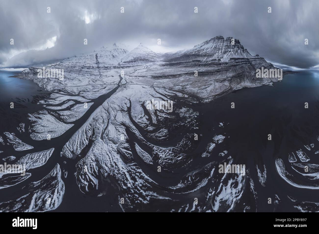 Scenic aerial view of river estuary located in valley near snowy ...