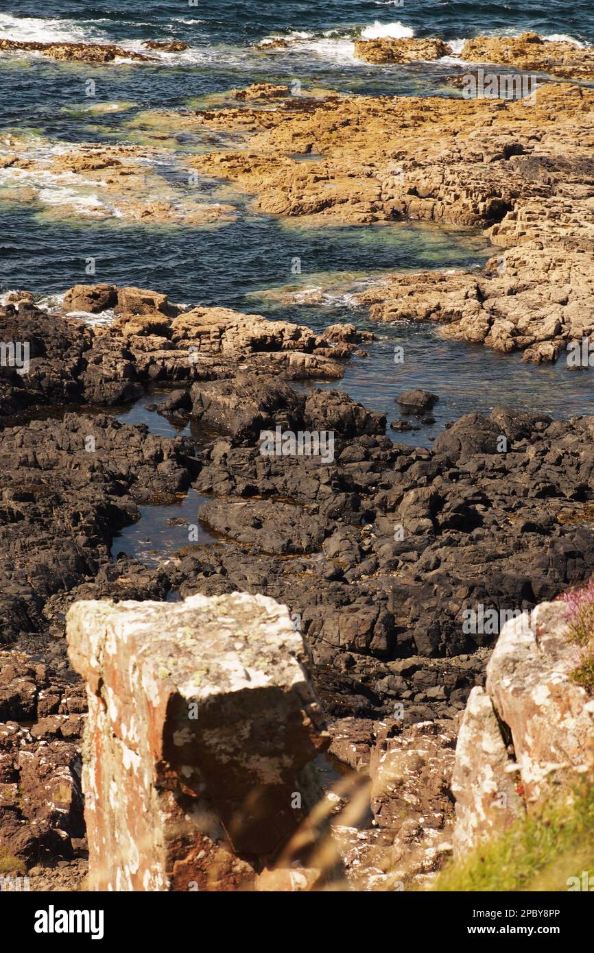 Looking down to a sheltered rockpools near Dun Ara Castle showing deep ...