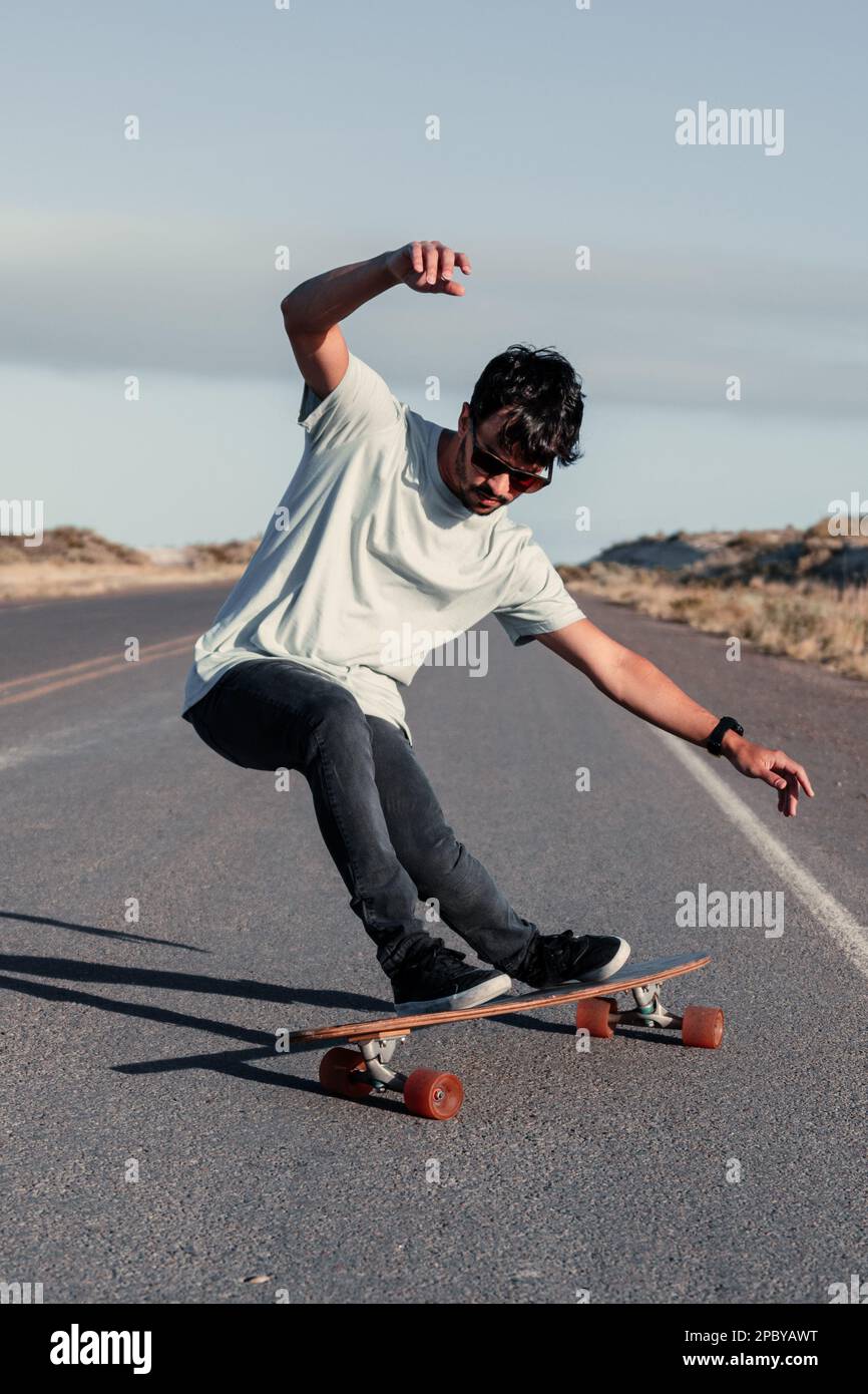 Full body of male skater in casual clothes performing extreme trick on ...