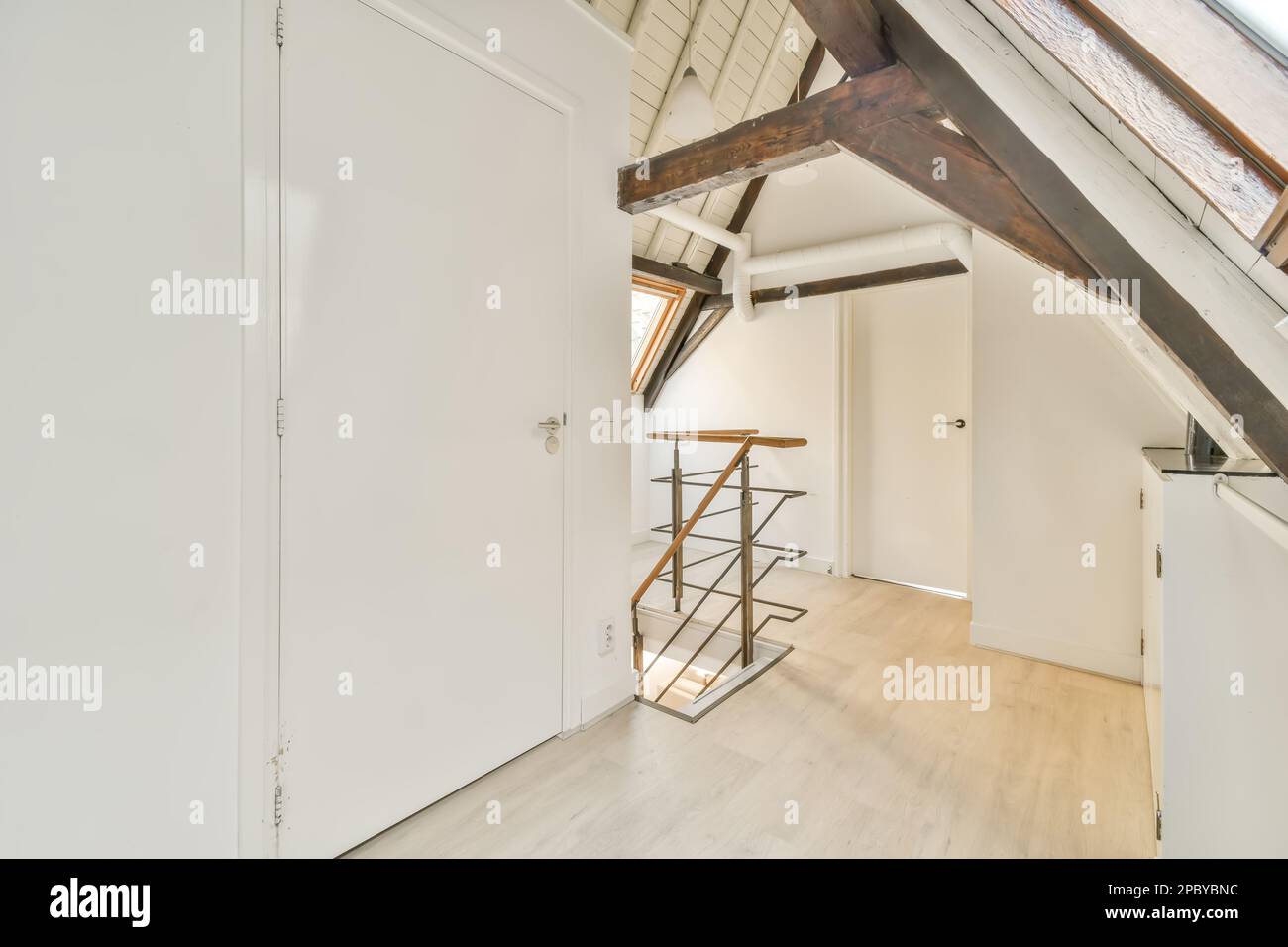 Contemporary white attic room with staircase and metal railings in ...