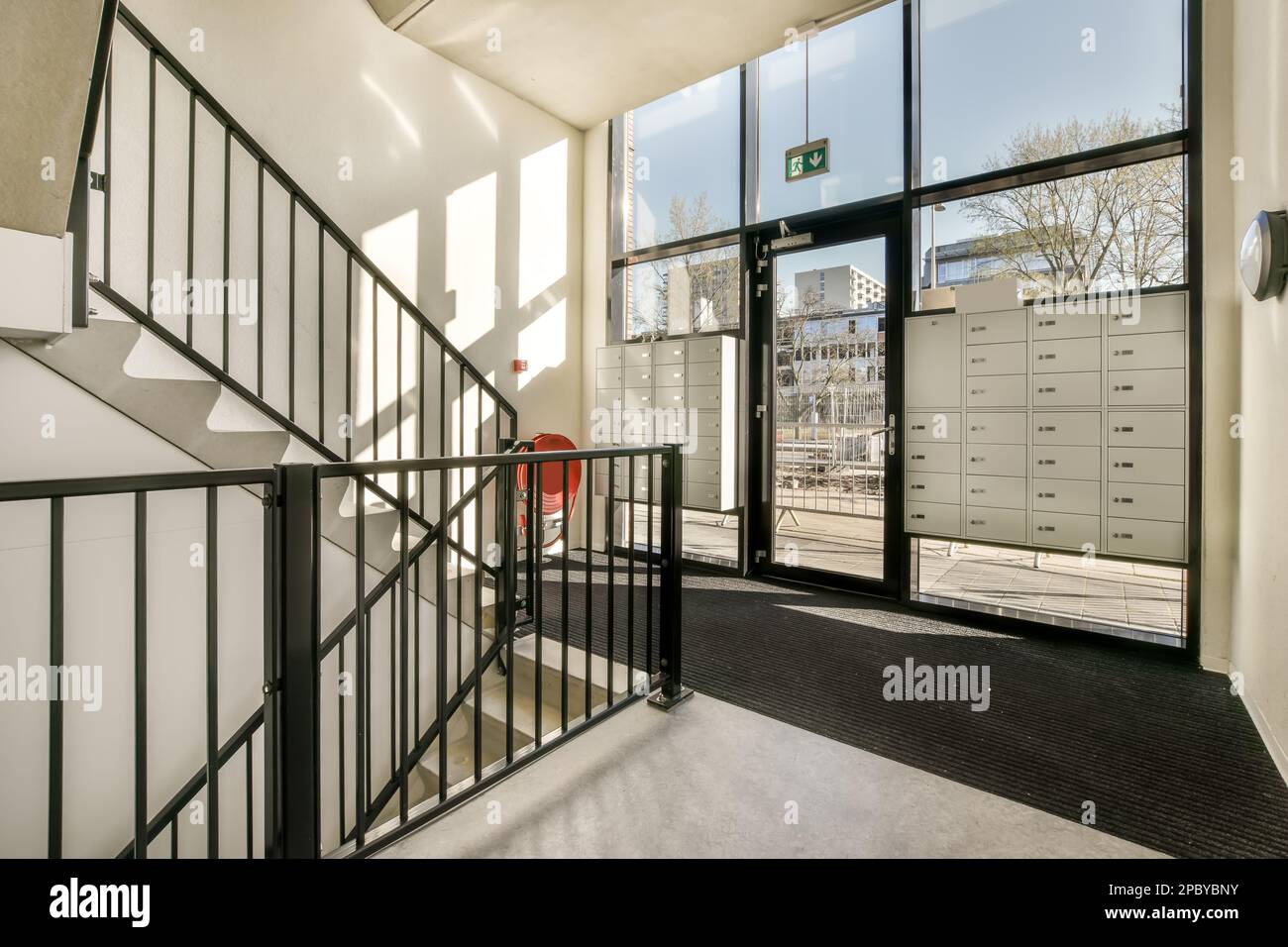 Hallway with mail boxes and black metal railings inside of residential ...