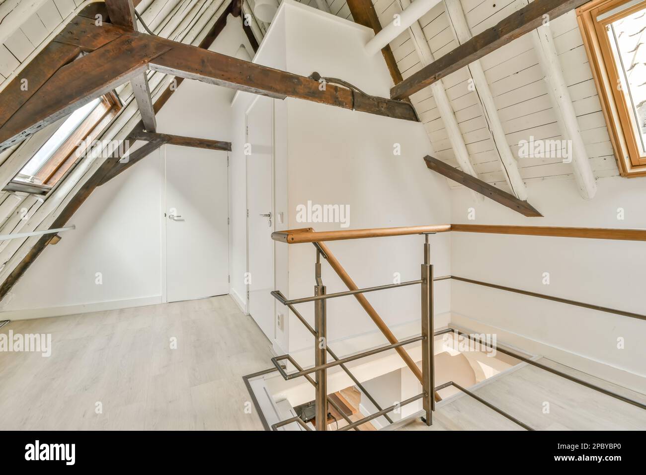 Contemporary white attic room with staircase and metal railings in ...