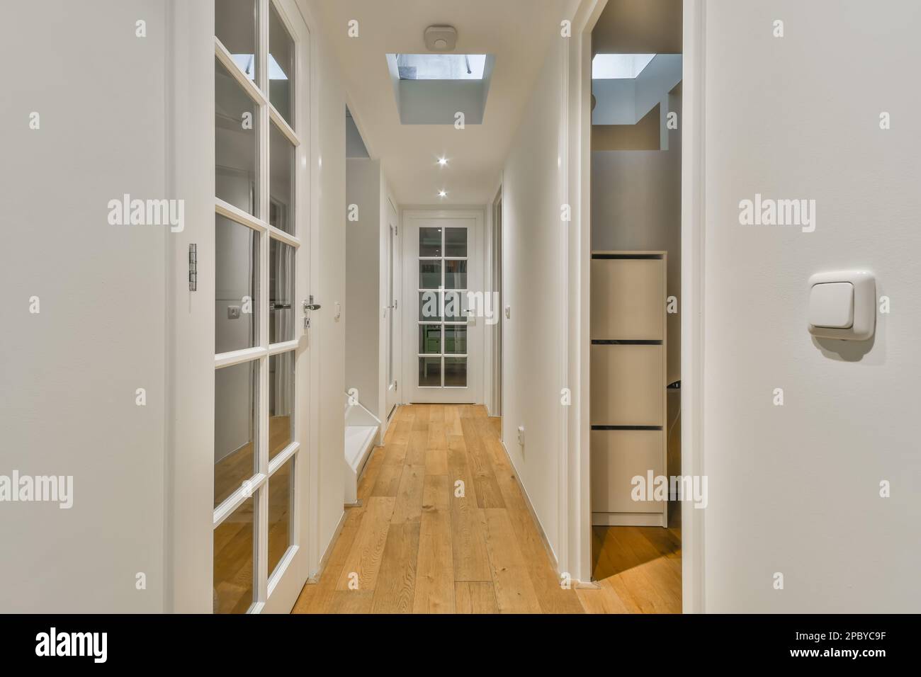Interior design of narrow empty hallway with glass doors and parquet ...