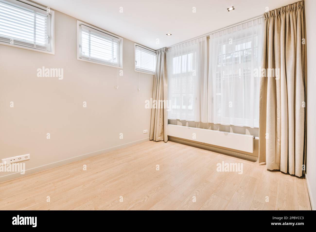 Interior of light empty room with windows decorated by curtains against ...