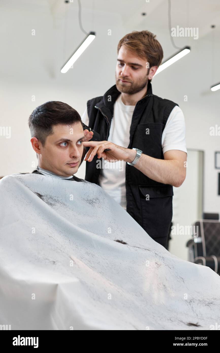 Barber making hairstyle confident hi-res stock photography and images ...