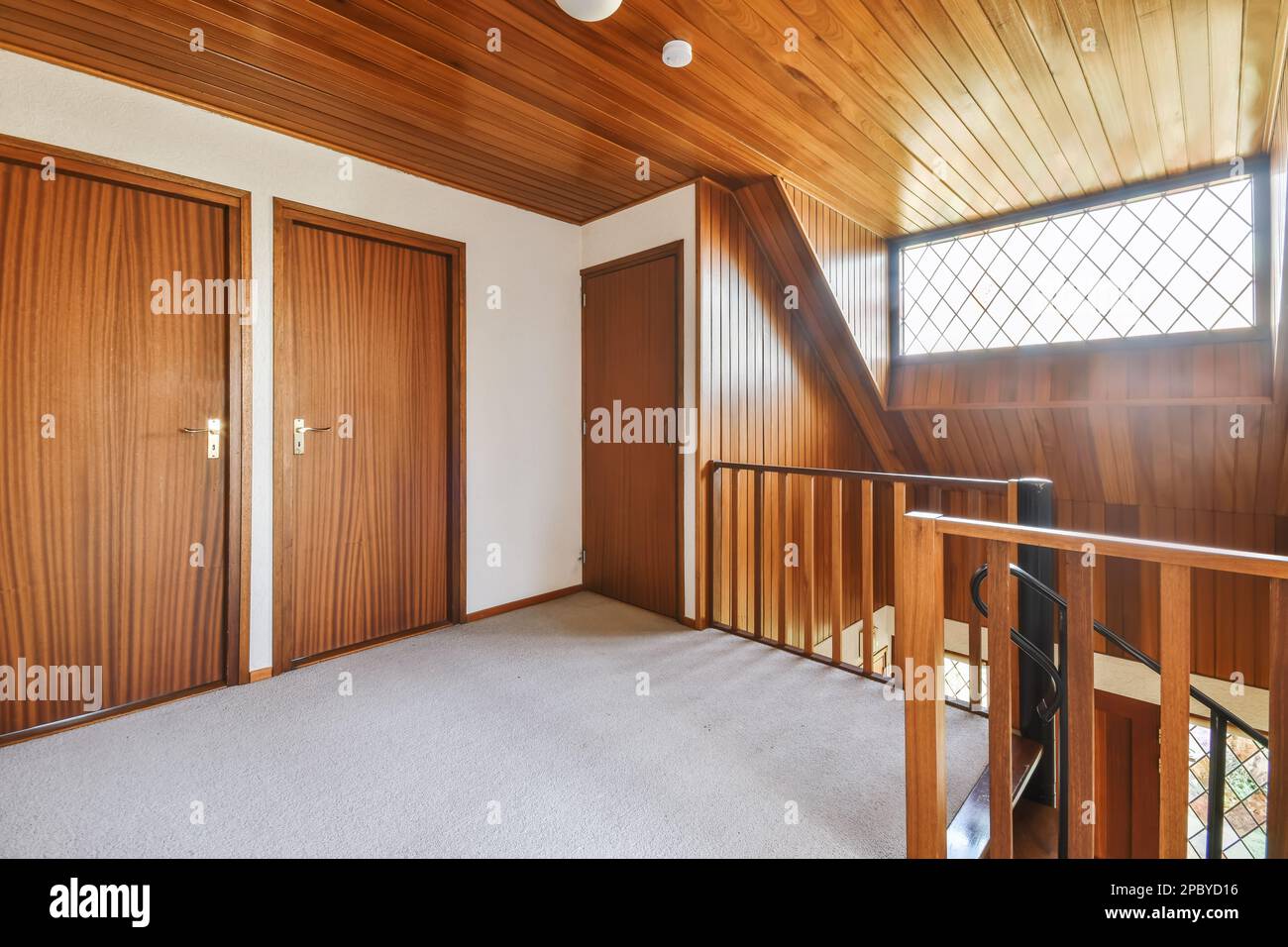 Interior design of spacious corridor with white walls and wooden doors ...
