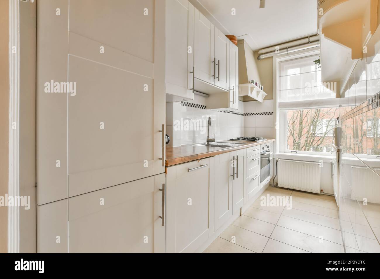 Interior design of contemporary kitchen with white cabinets and stone ...