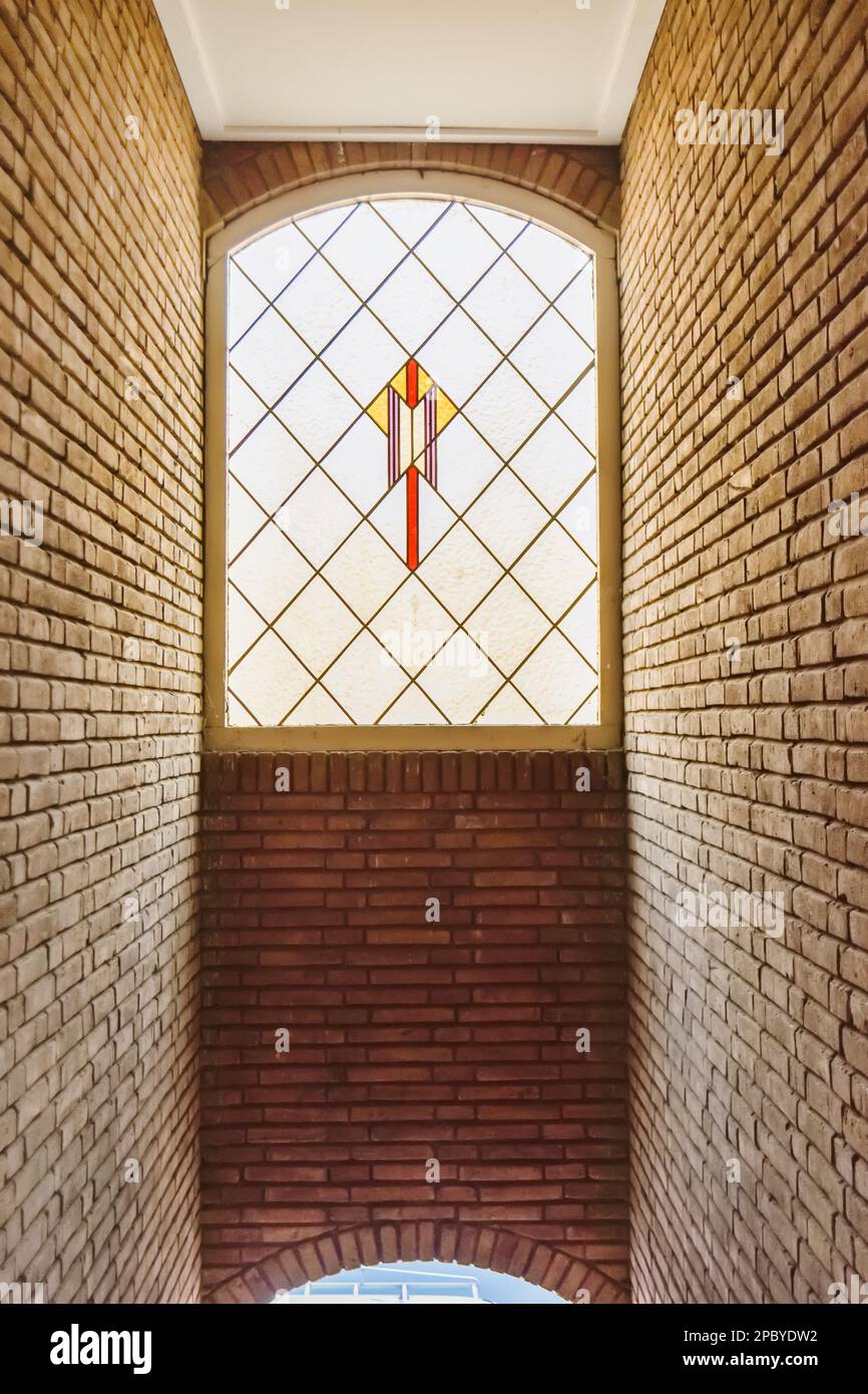 Daylight wide angle view of narrow brown brick walled passage of ...