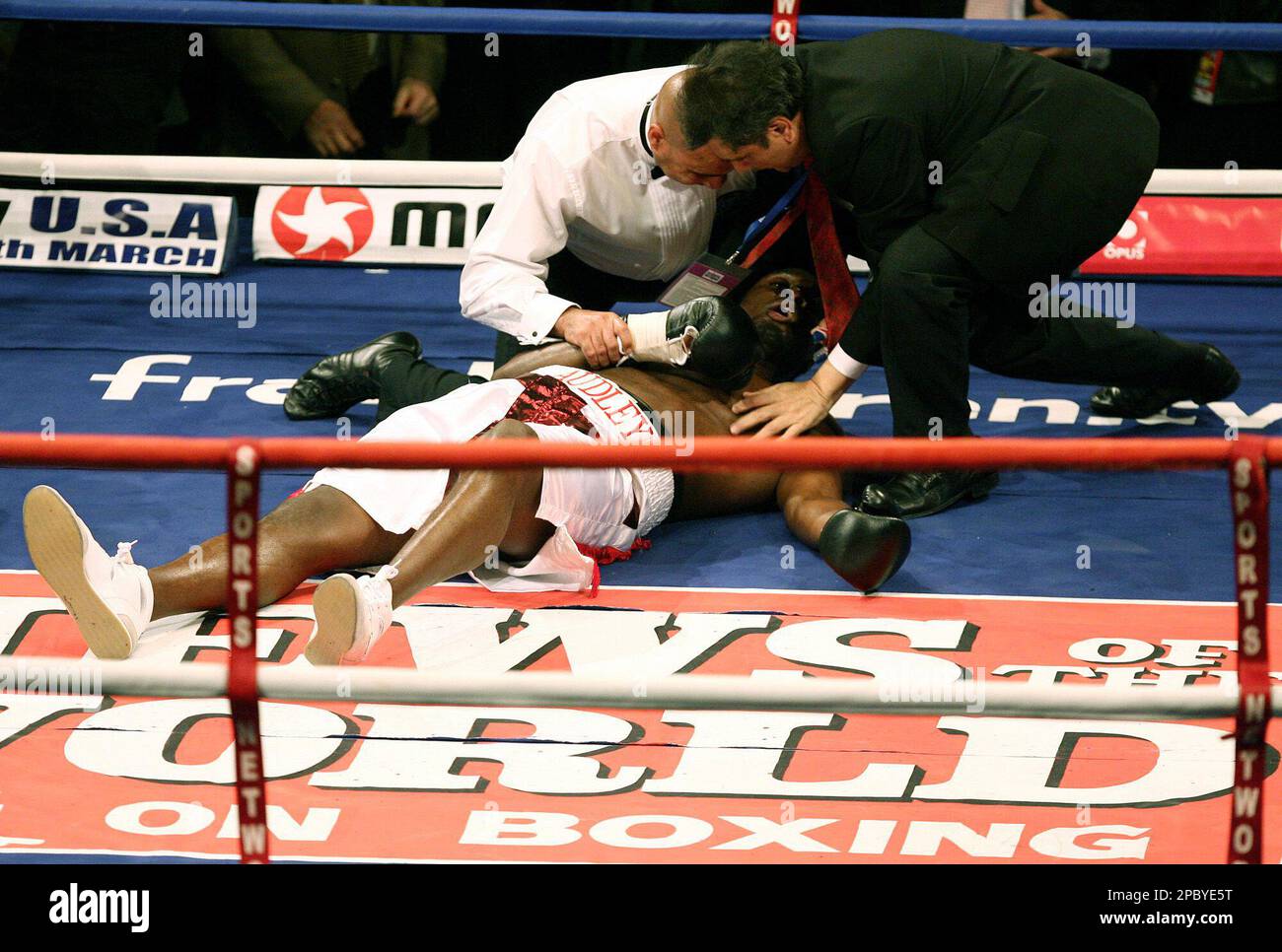 British boxer, Audley Harrison, center, is seen to by the referee, left ...