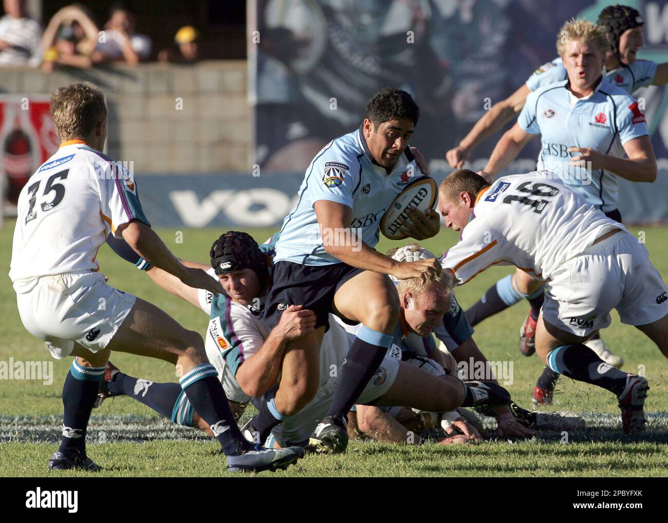 Australia's Waratahs Morgan Turinui, center, is tackled by South Africa ...