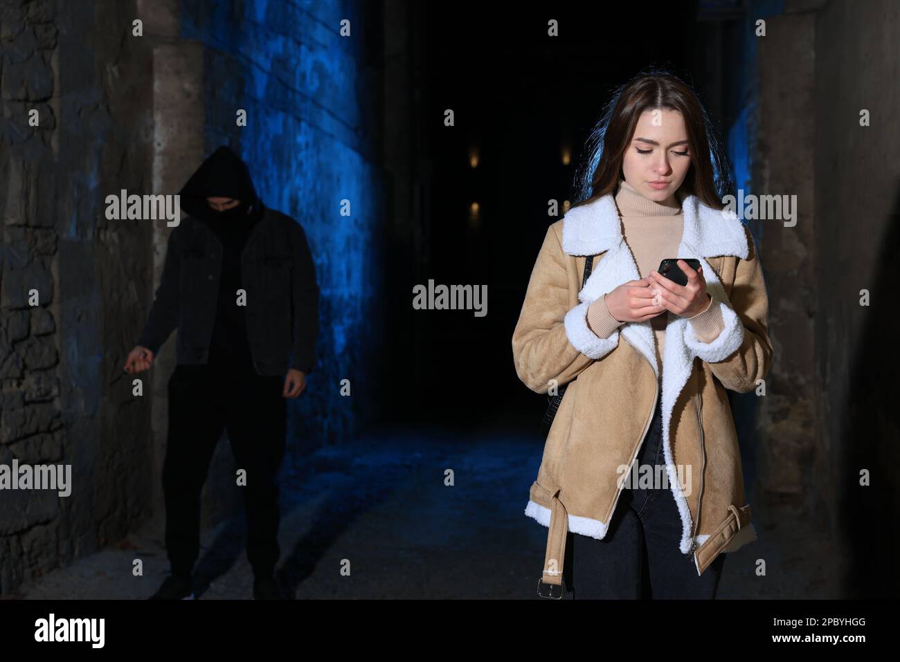 Man with knife stalking young woman in alley at night Stock Photo - Alamy