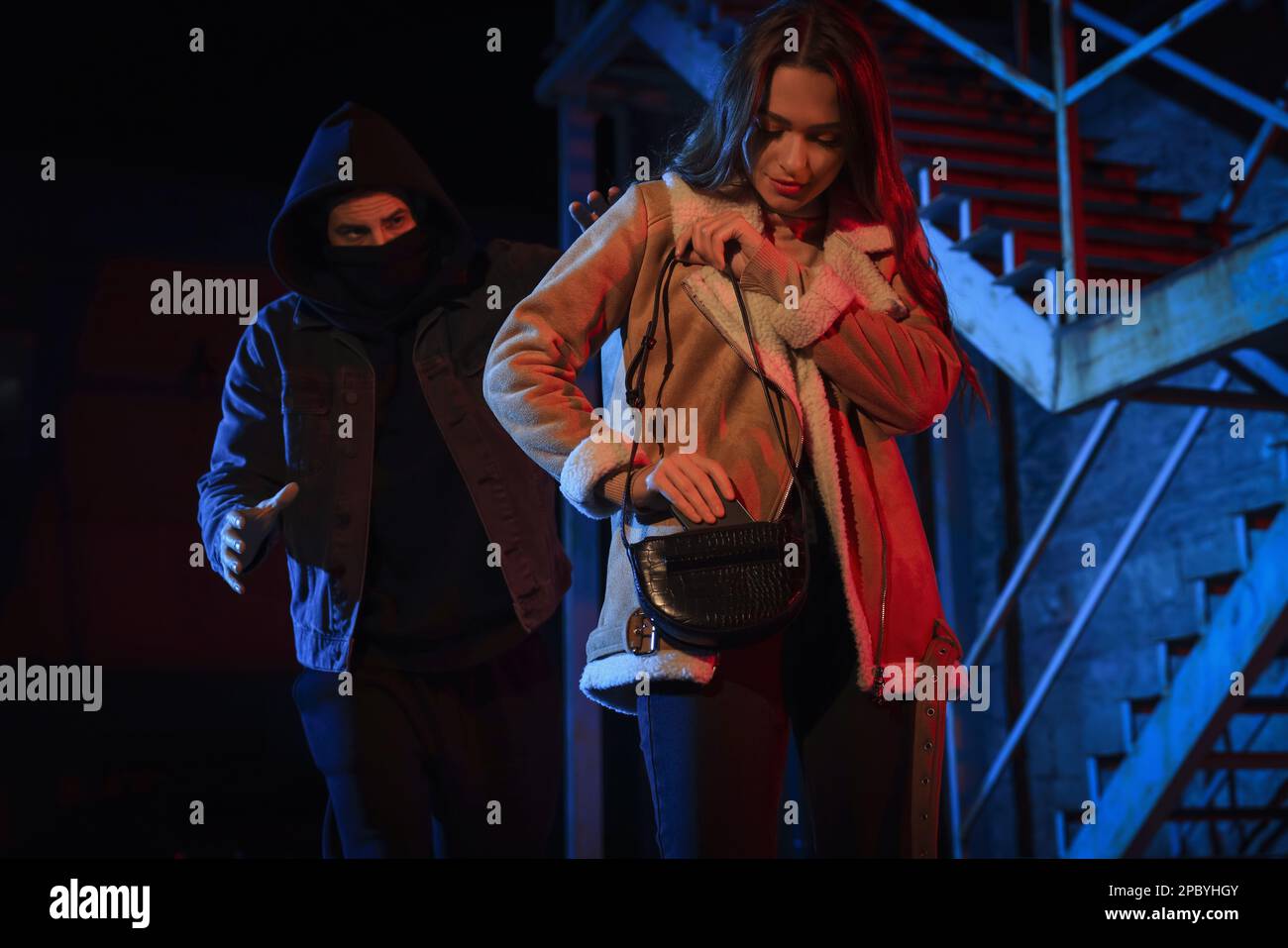 Criminal attacking young woman outdoors at night. Self defense concept ...