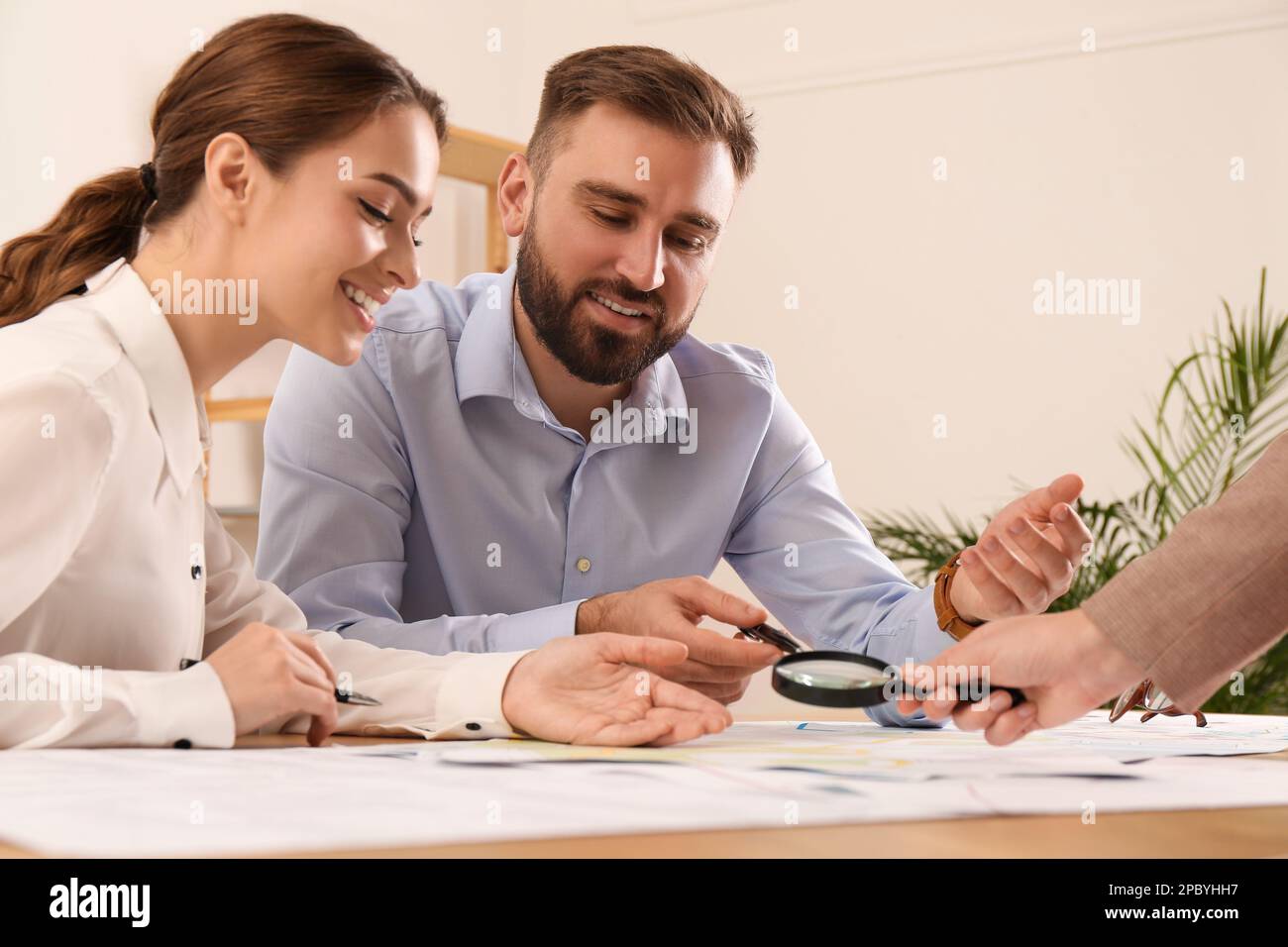 Professional cartographers working with cadastral map at table in ...