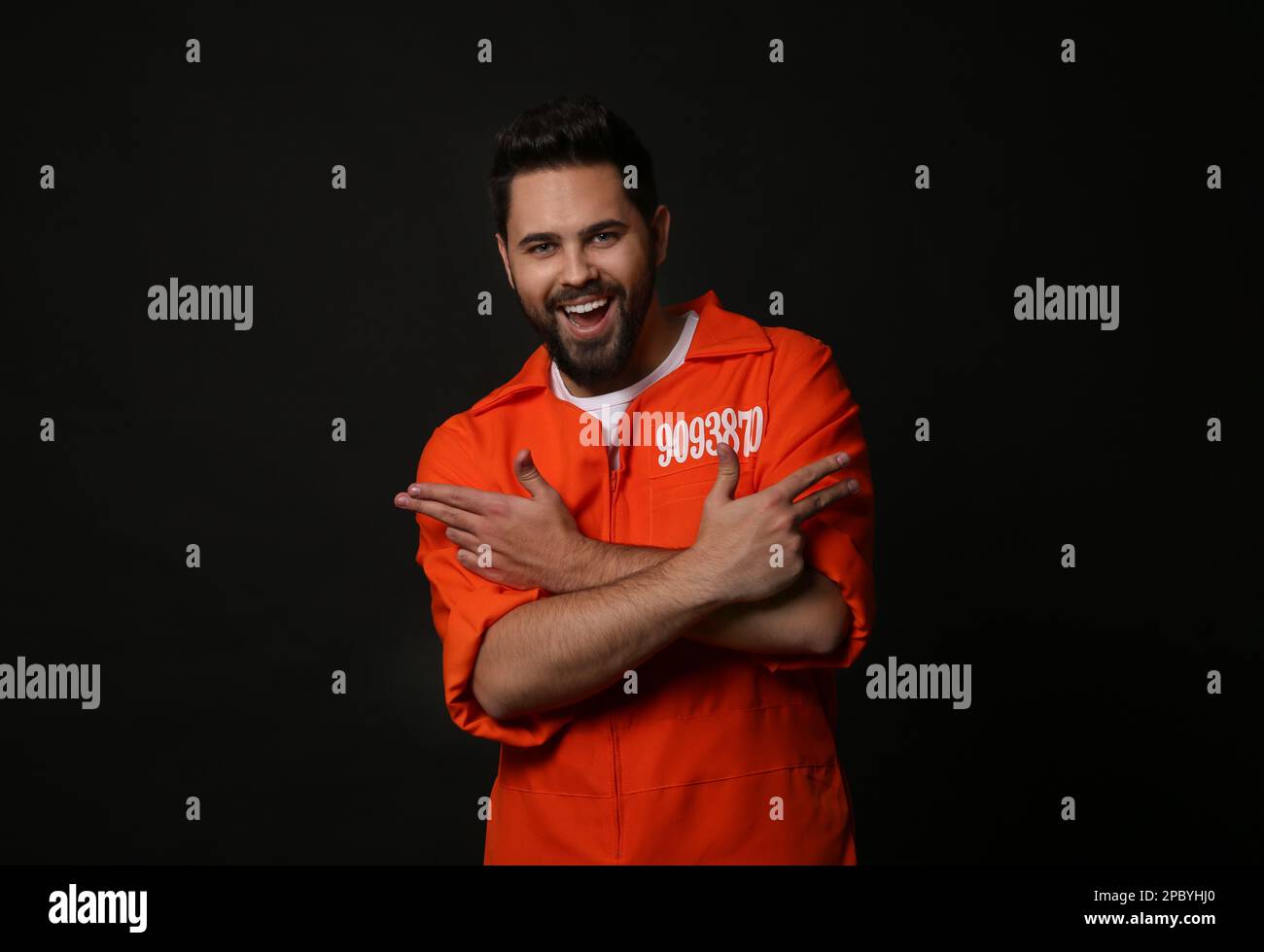 Happy prisoner in jumpsuit on black background Stock Photo - Alamy
