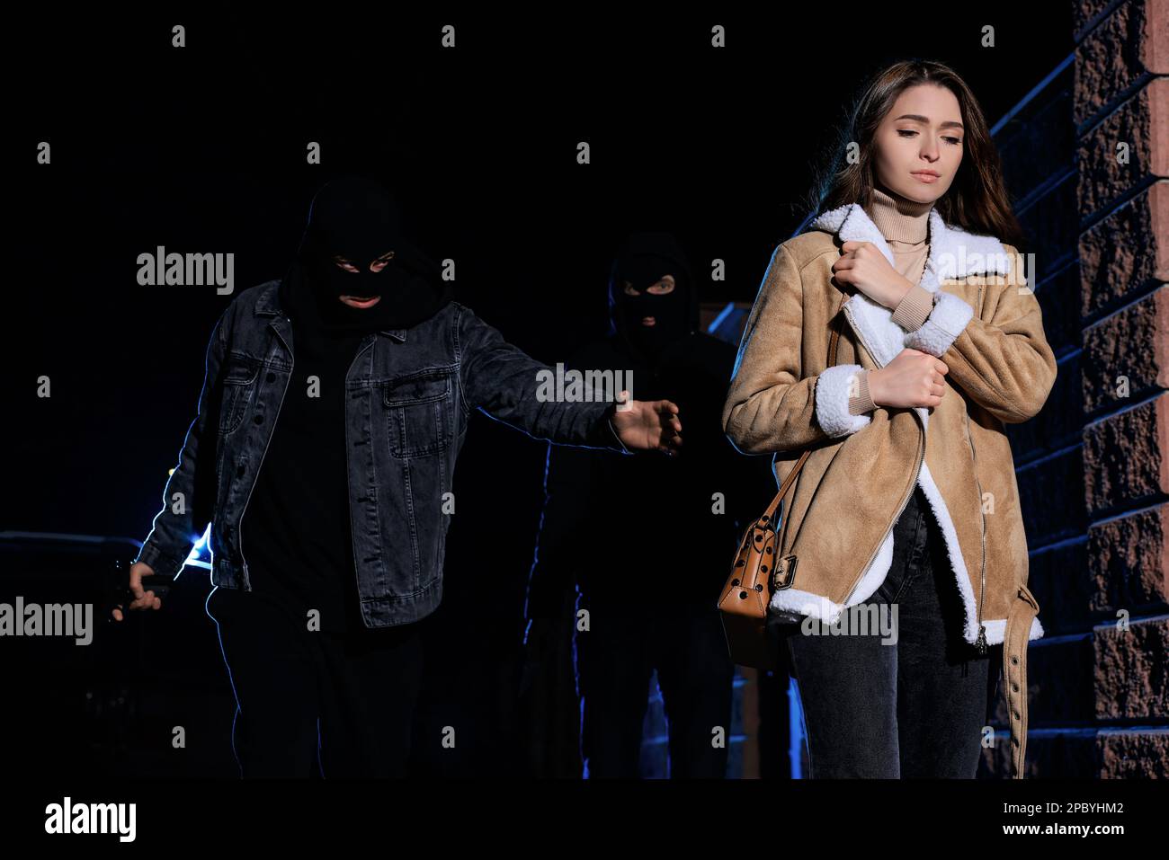 Criminals in masks attacking young woman outdoors at night. Self ...