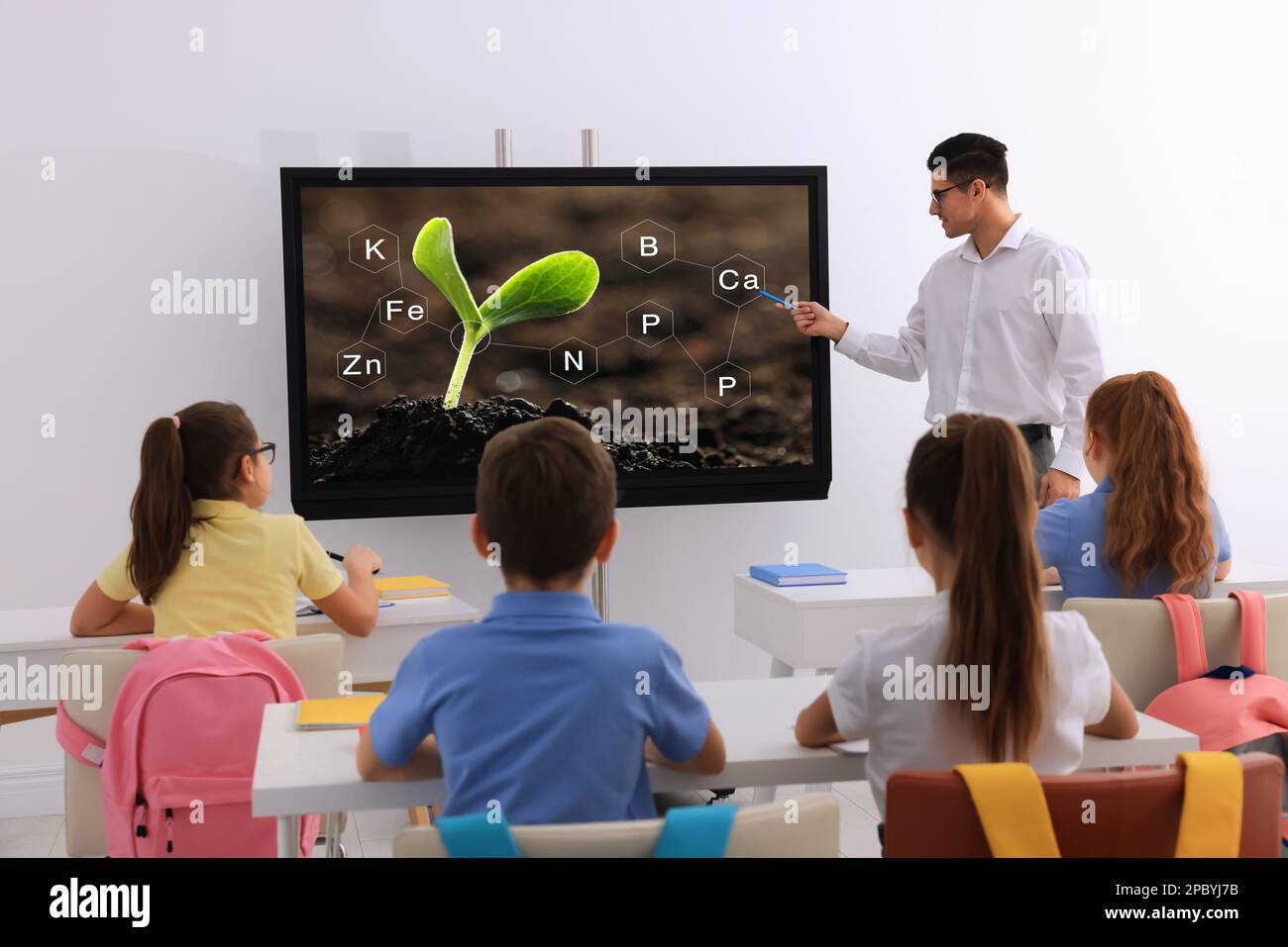 Teacher using interactive board in classroom during lesson Stock Photo ...