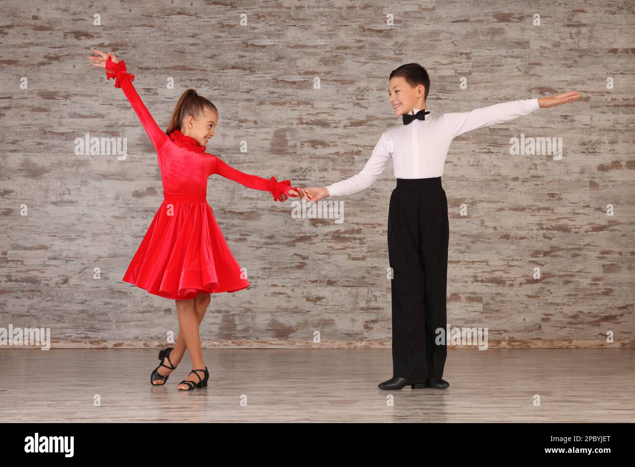 Beautifully dressed couple of kids dancing together in studio Stock ...