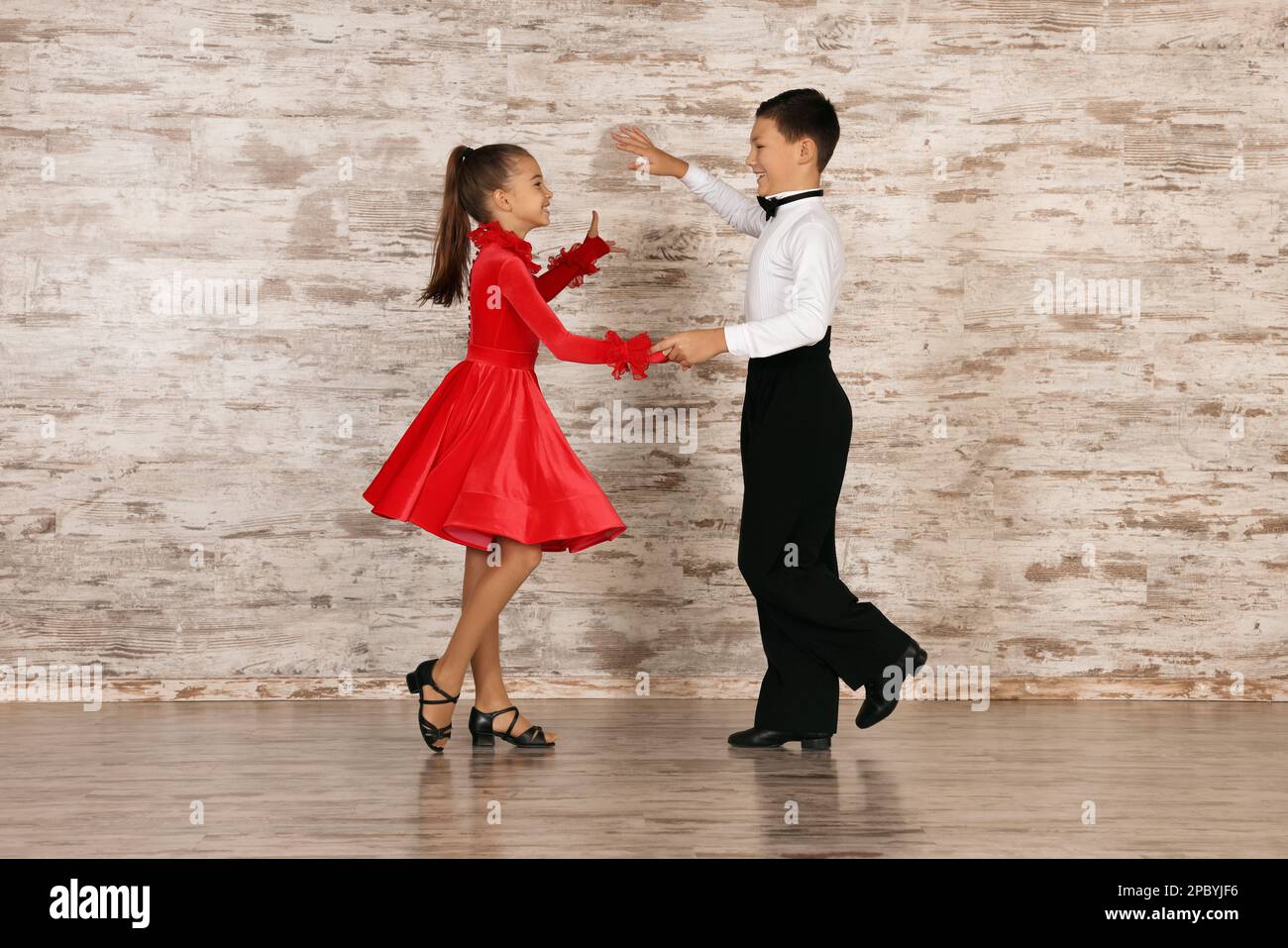 Beautifully dressed couple of kids dancing together in studio Stock ...