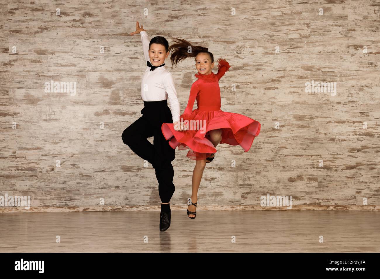 Beautifully dressed couple of kids dancing together in studio Stock ...