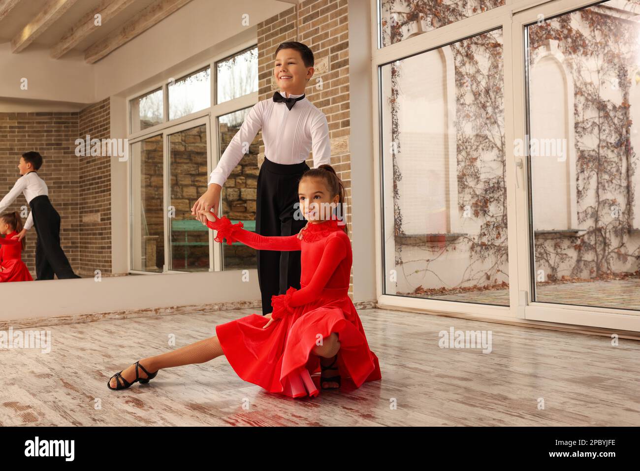 Beautifully dressed couple of kids dancing together in studio Stock ...