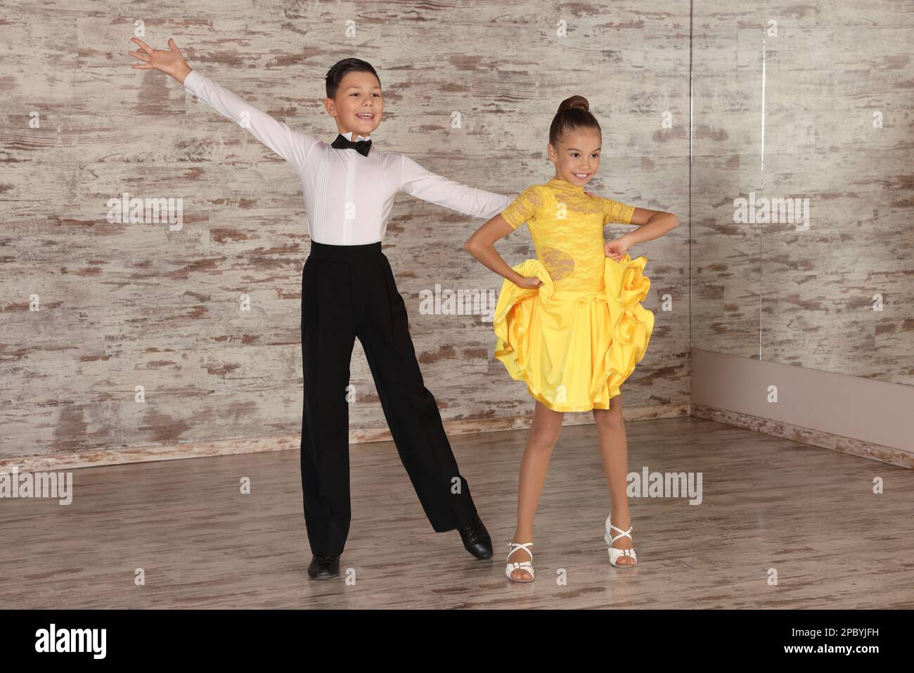 Beautifully dressed couple of kids dancing together in studio Stock ...