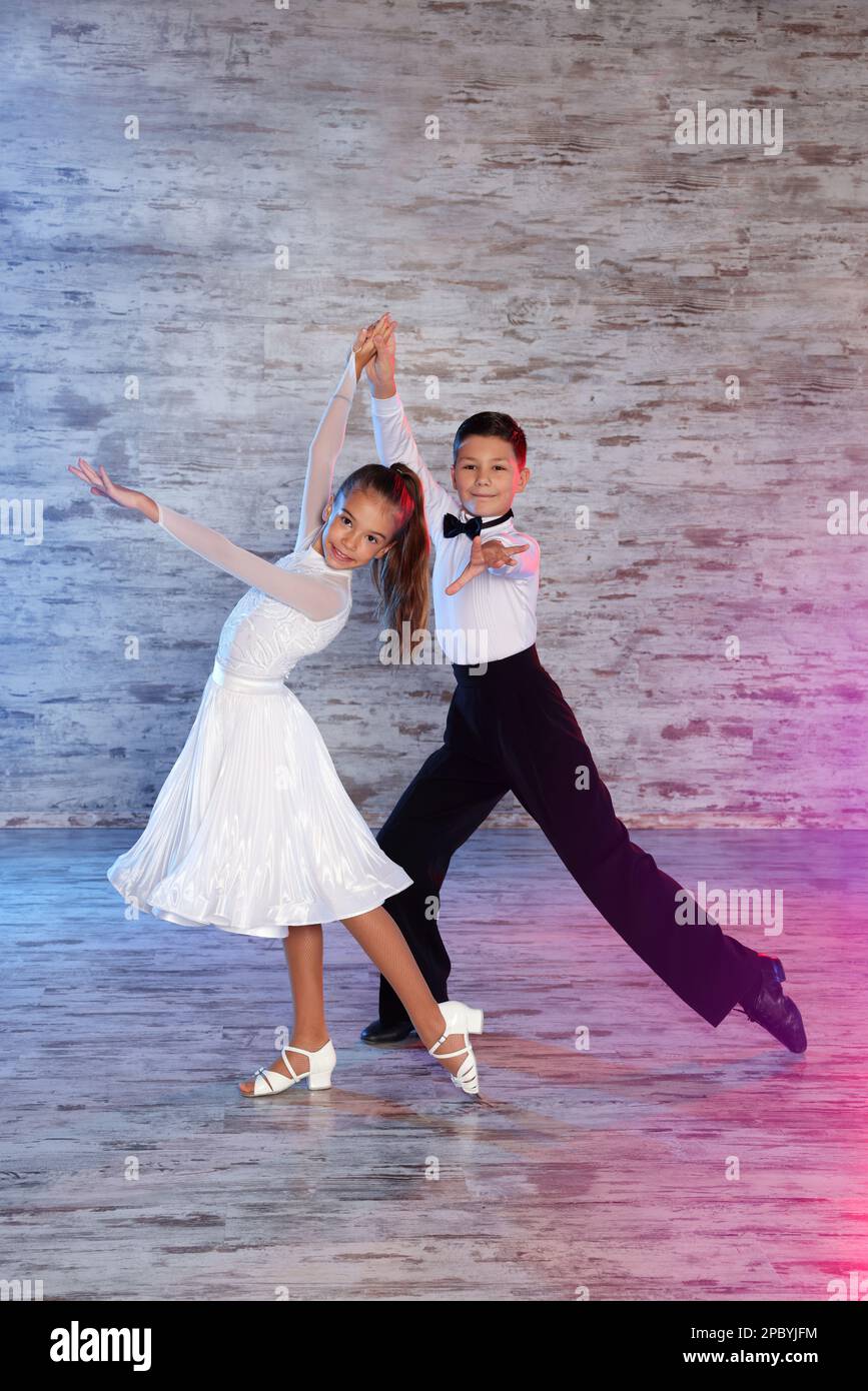 Beautifully dressed couple of kids dancing together in studio Stock ...