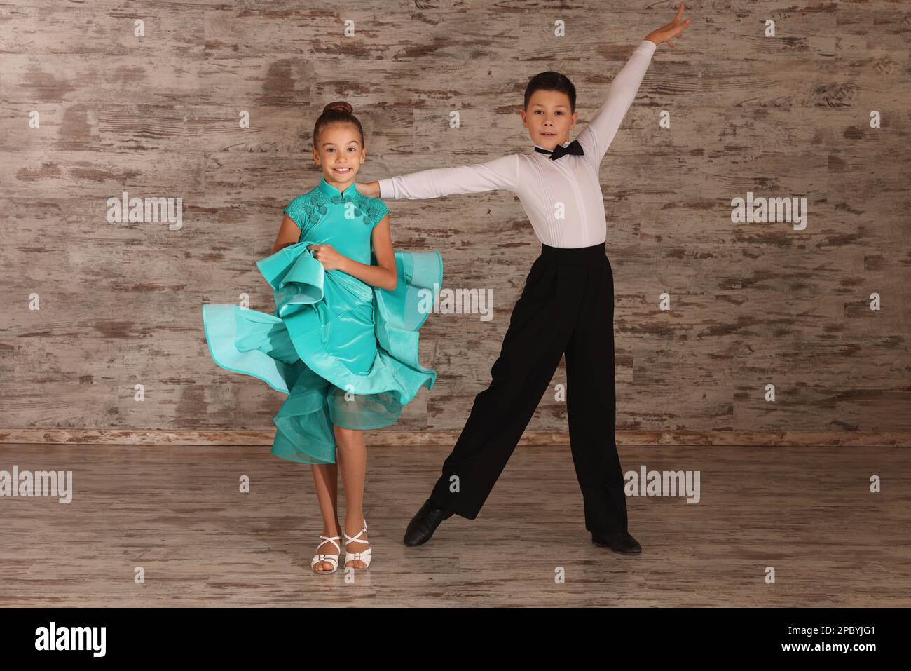 Beautifully dressed couple of kids dancing together in studio Stock ...