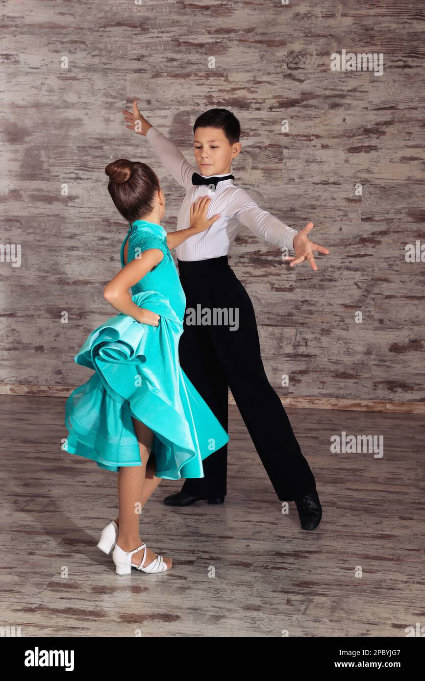 Beautifully dressed couple of kids dancing together in studio Stock ...