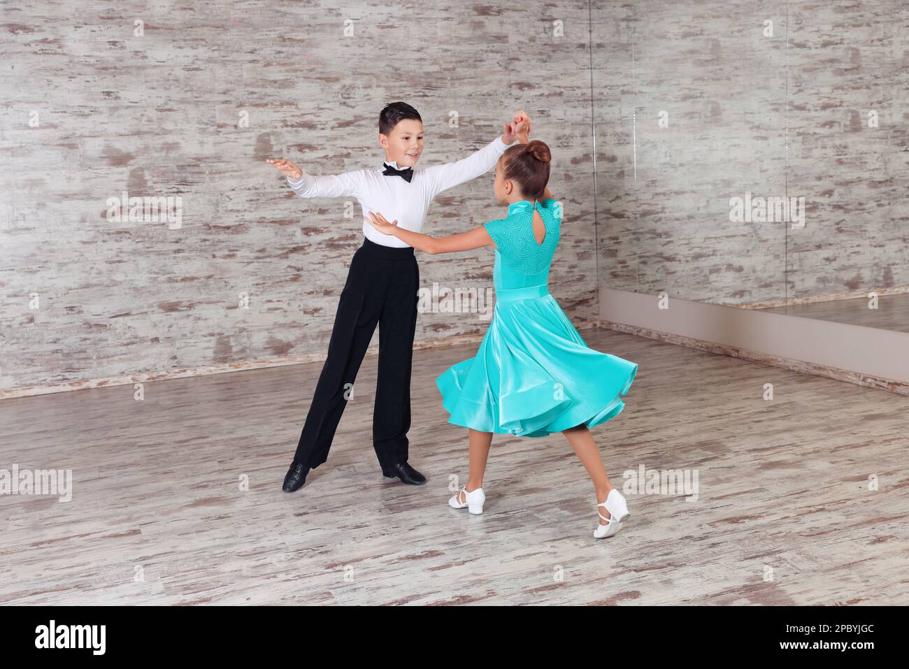 Beautifully dressed couple of kids dancing together in studio Stock ...