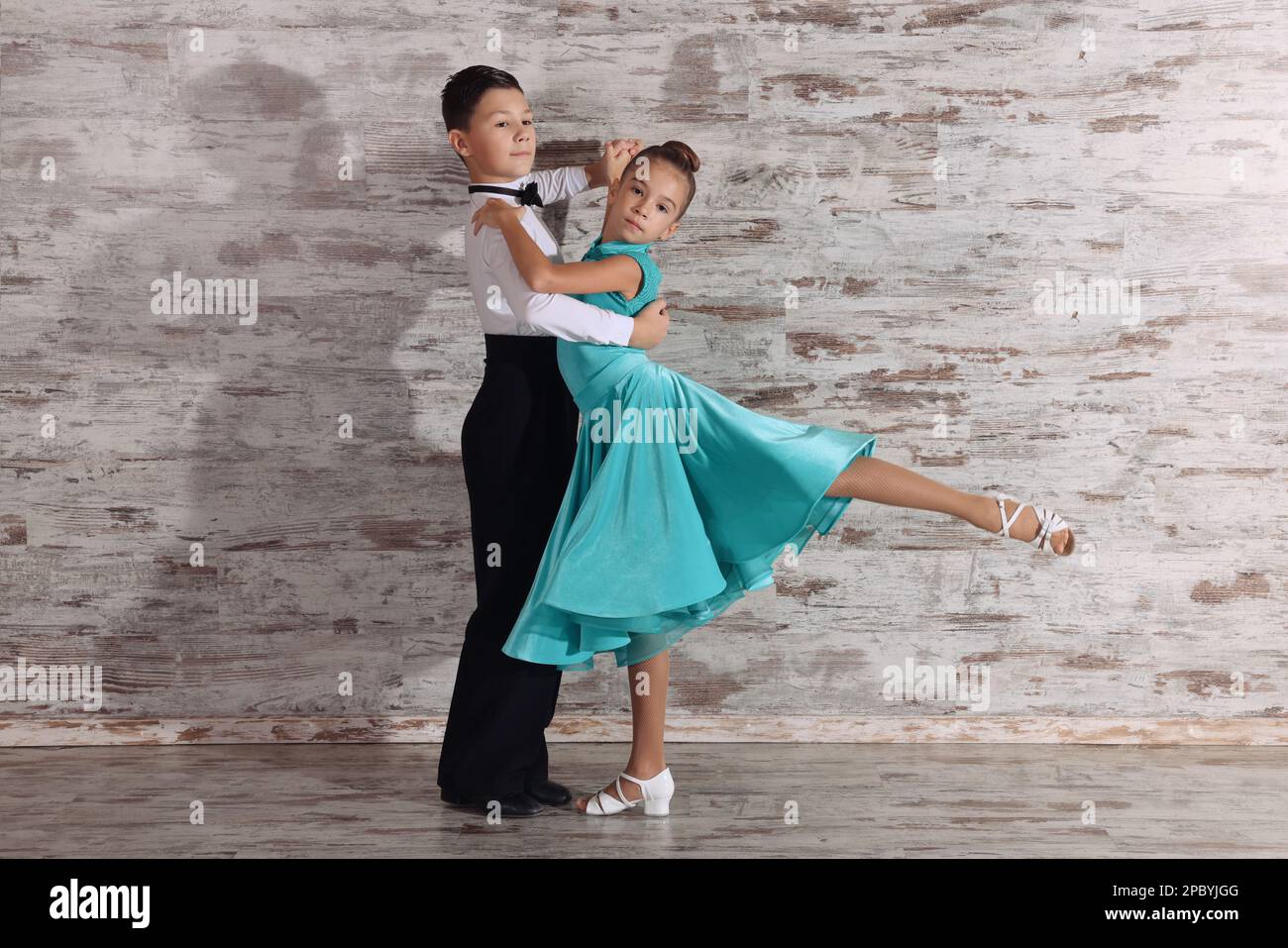 Beautifully dressed couple of kids dancing together in studio Stock ...