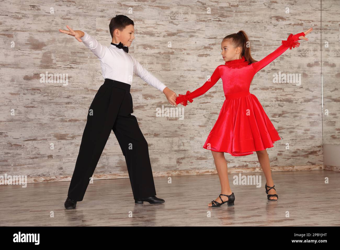 Beautifully dressed couple of kids dancing together in studio Stock ...
