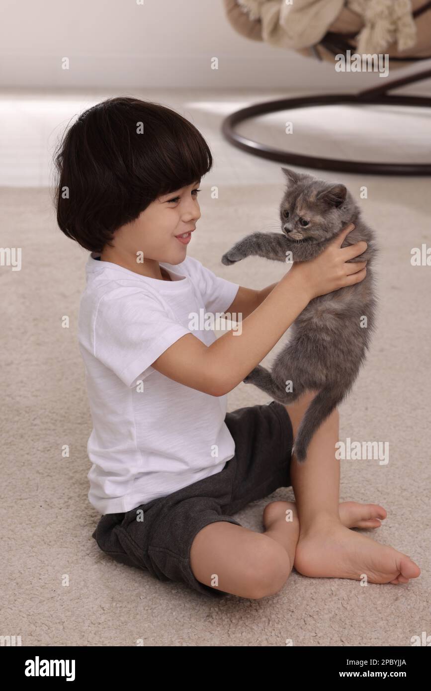 Cute little boy with kitten on floor at home. Childhood pet Stock Photo ...