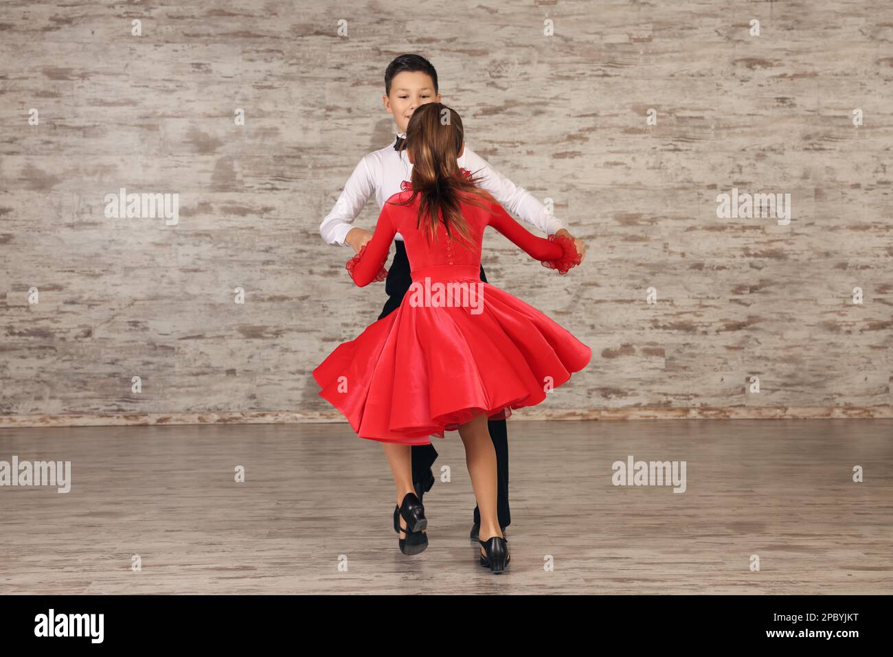 Beautifully dressed couple of kids dancing together in studio Stock ...