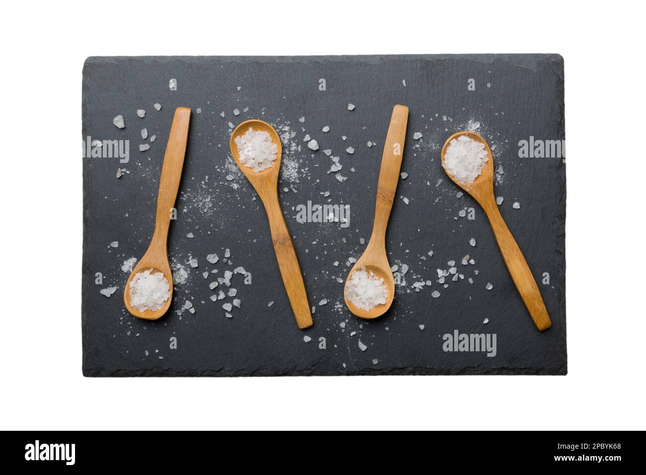 salt on many wooden spoon isolated on white background. Spoons with ...