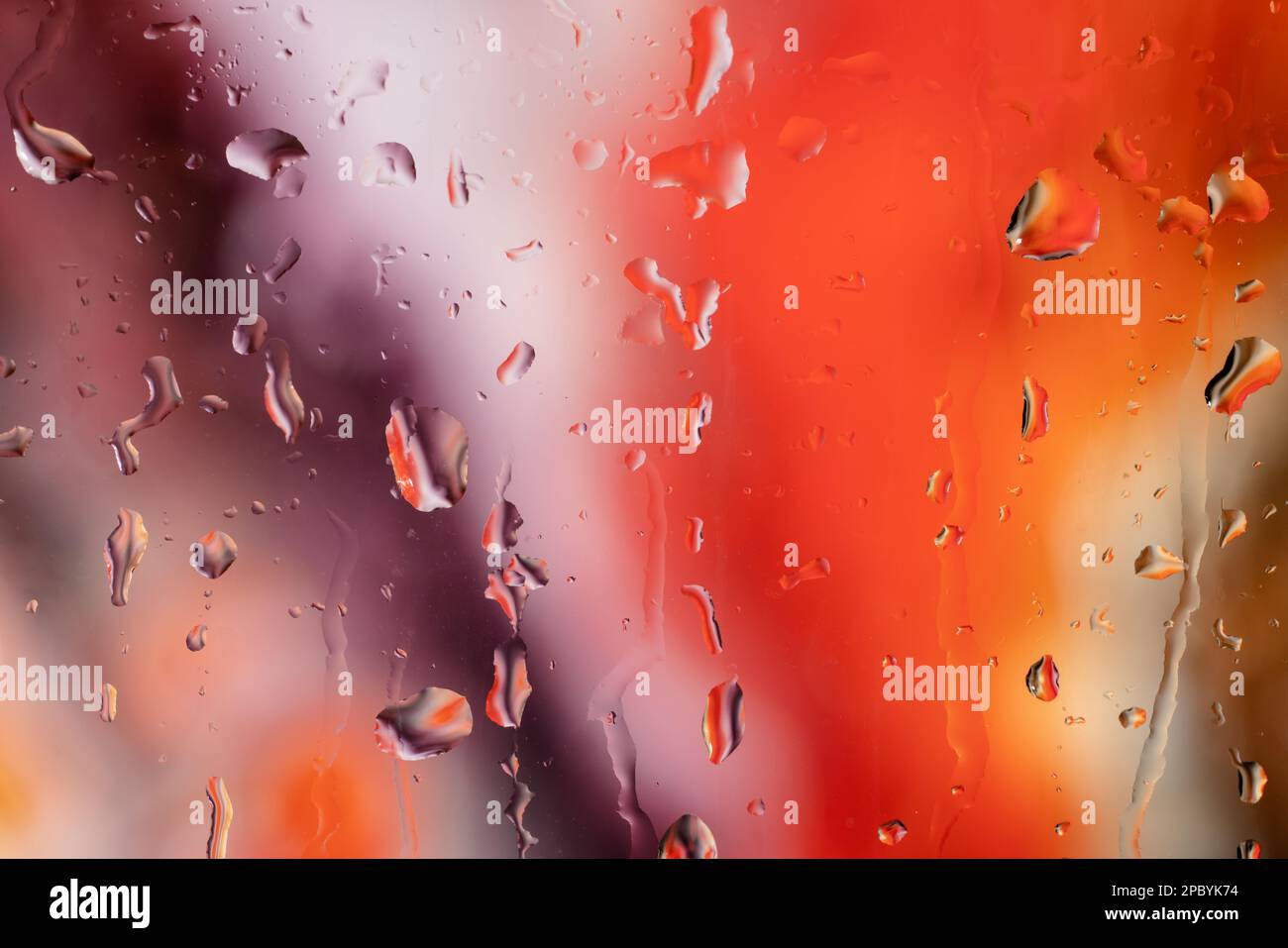 Closeup through window of rainy day with water dripping down glass ...