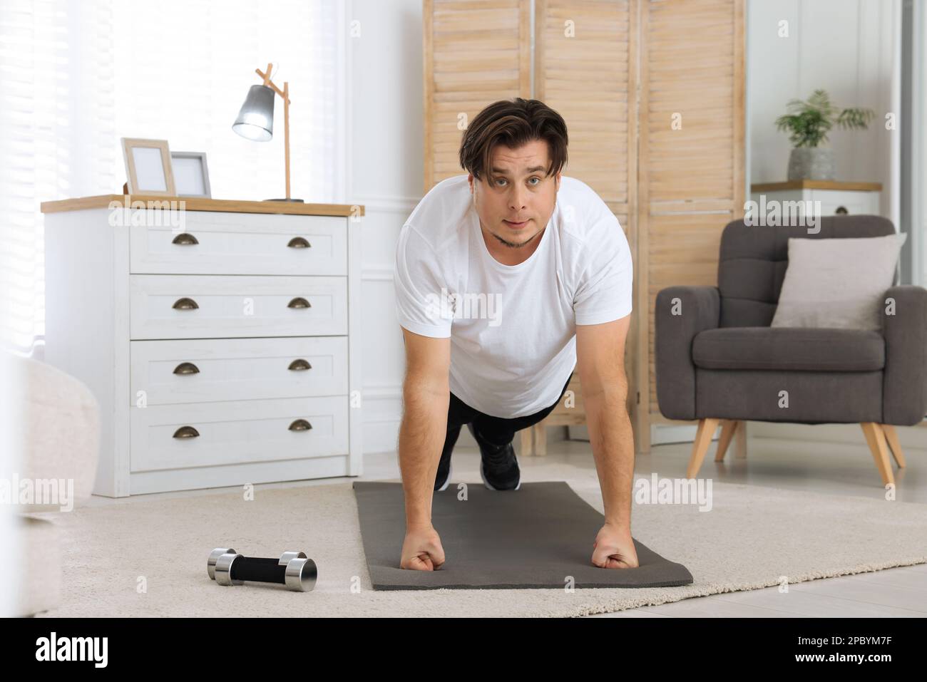 Obese man doing yoga on mat hi-res stock photography and images - Alamy