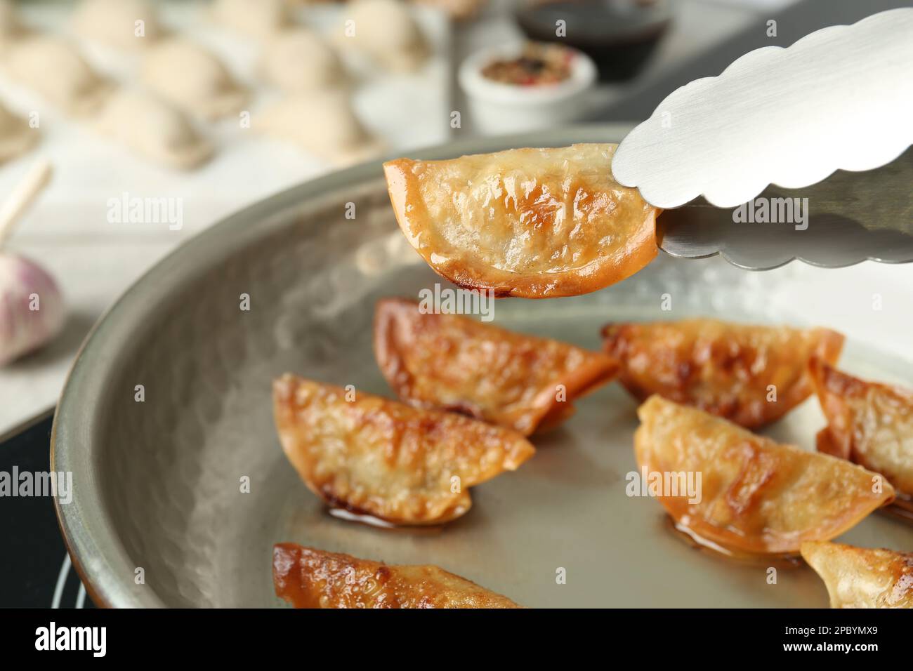 Cooking gyoza on frying pan with hot oil in kitchen, closeup Stock ...