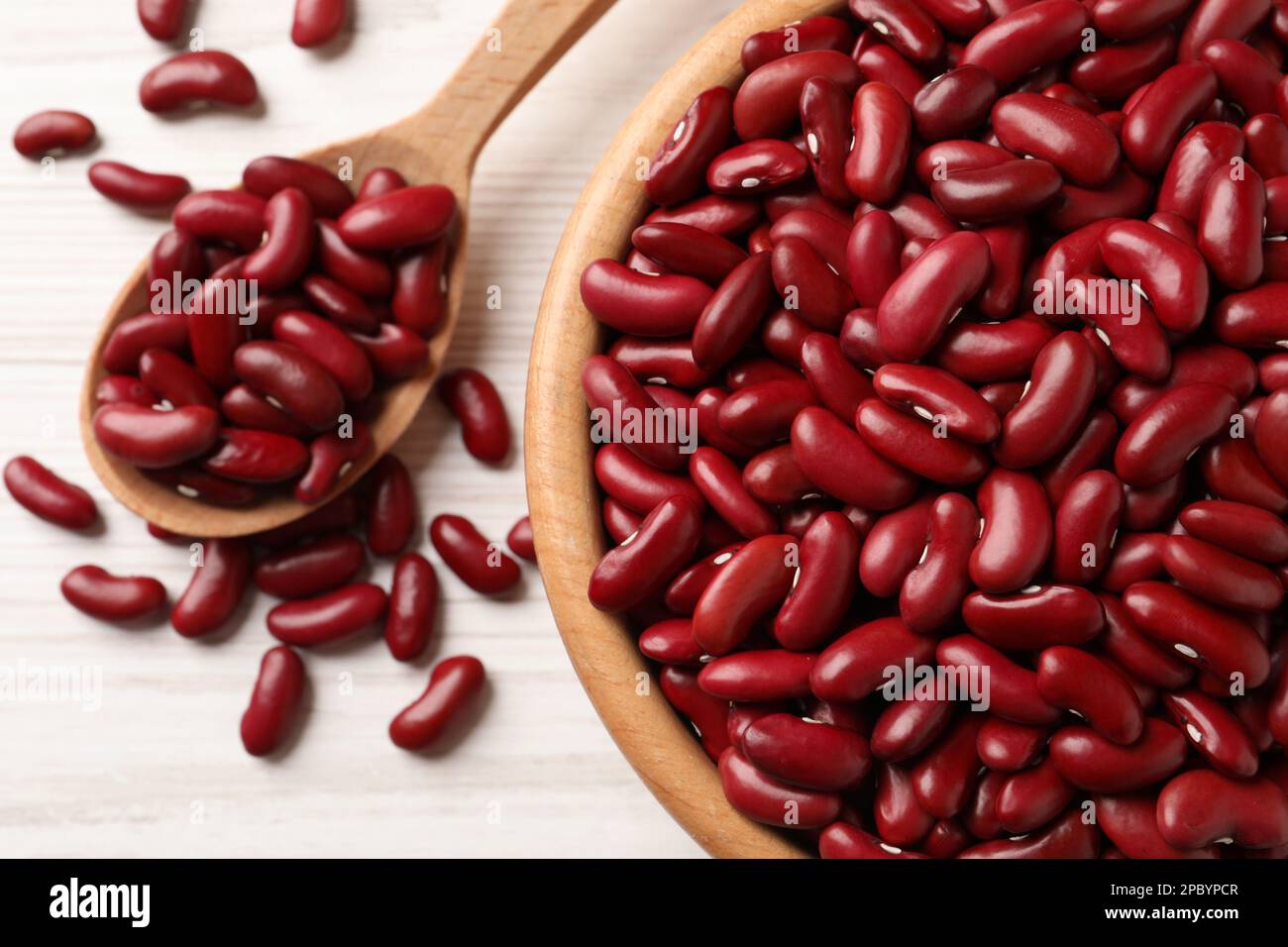 Raw red kidney beans with bowl and spoon on white wooden table, top ...