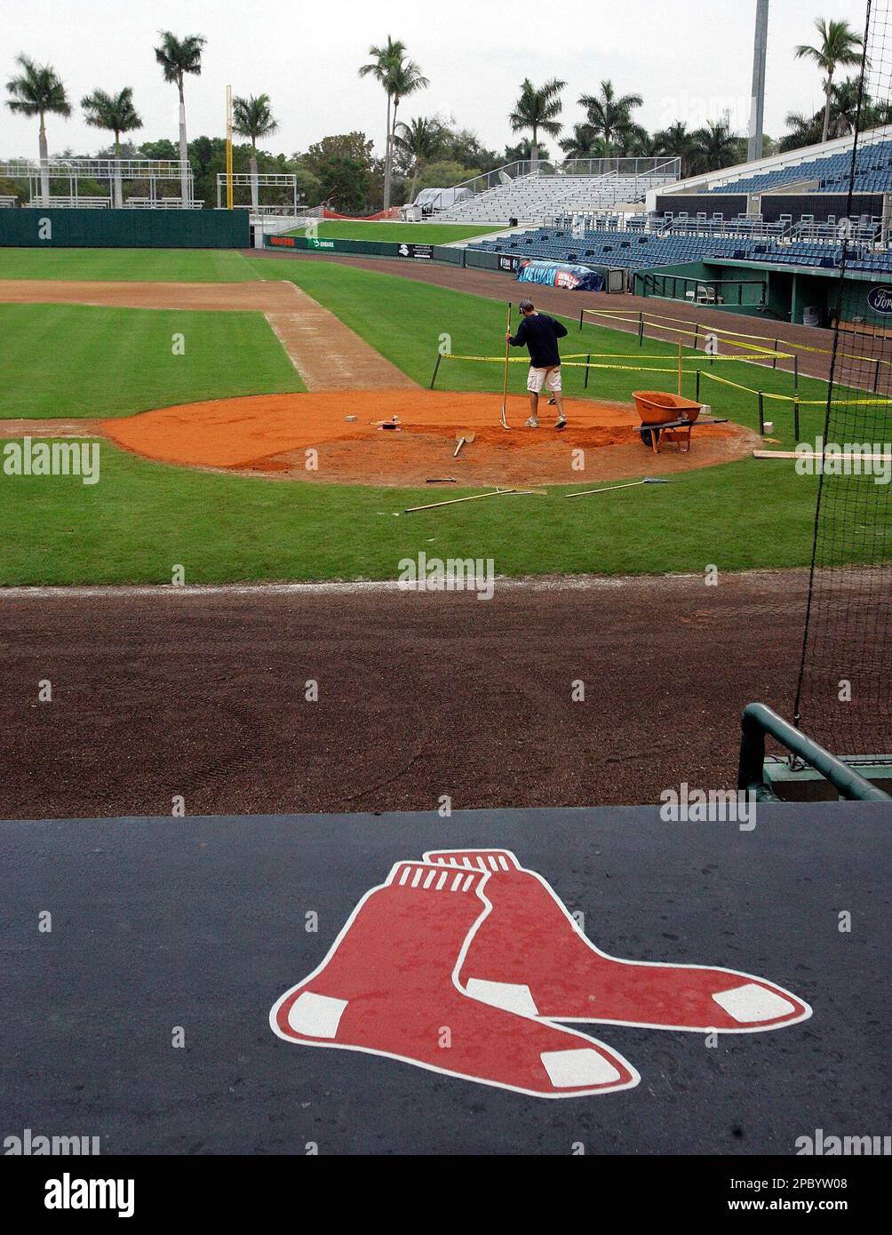 A groundscrew members works around home plate works at City of Palms ...